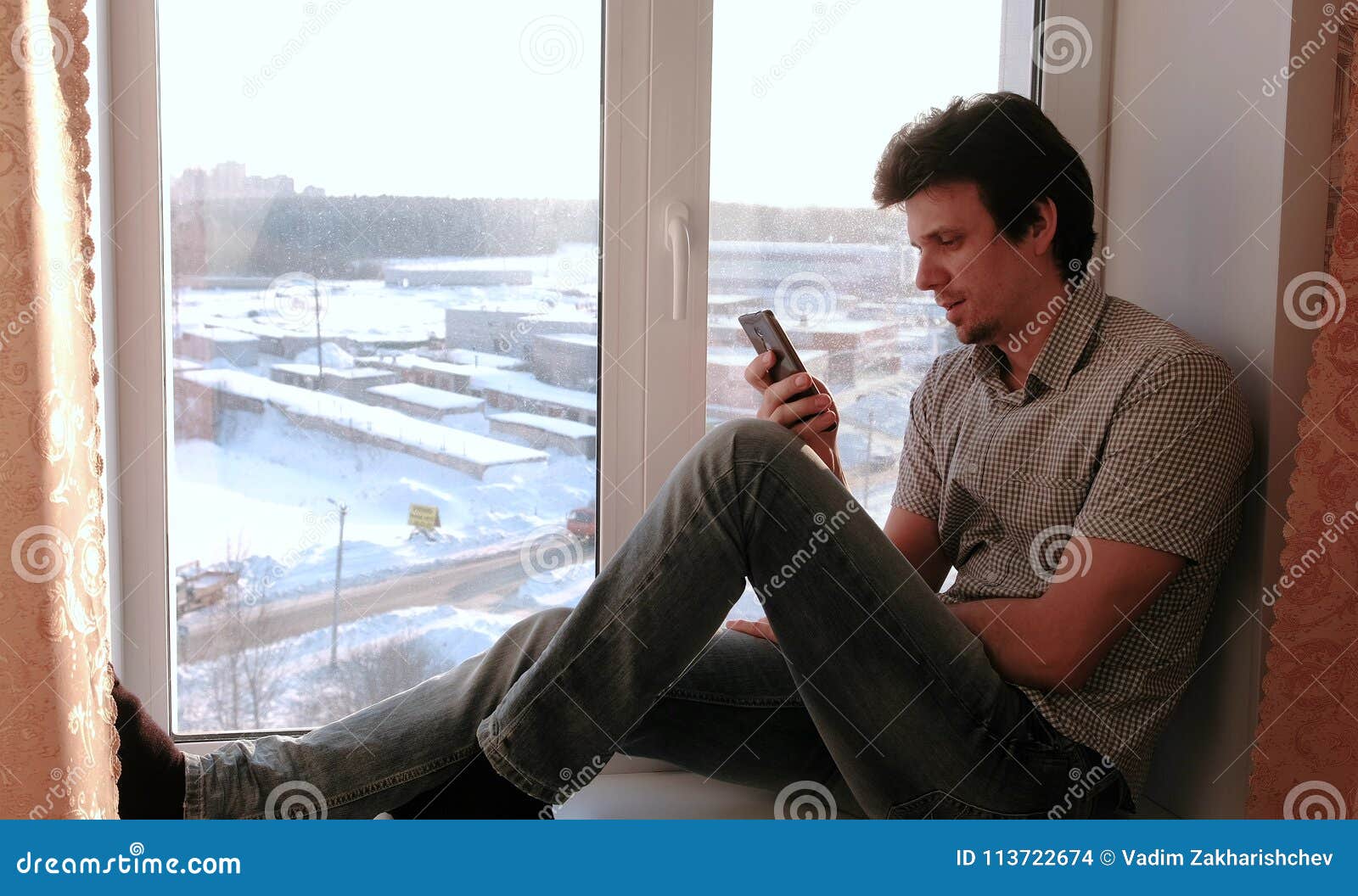 Man Watches Something on the Internet in His Mobile while Sitting on a ...