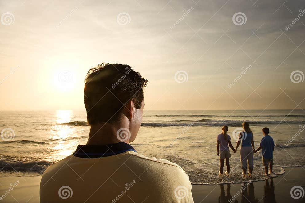 Man Watching Family at Beach Stock Image - Image of outdoors, coast ...