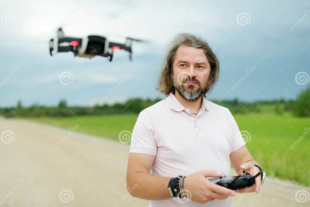 Man Watching and Navigating a Drone. Man Operating the Drone by Remote ...