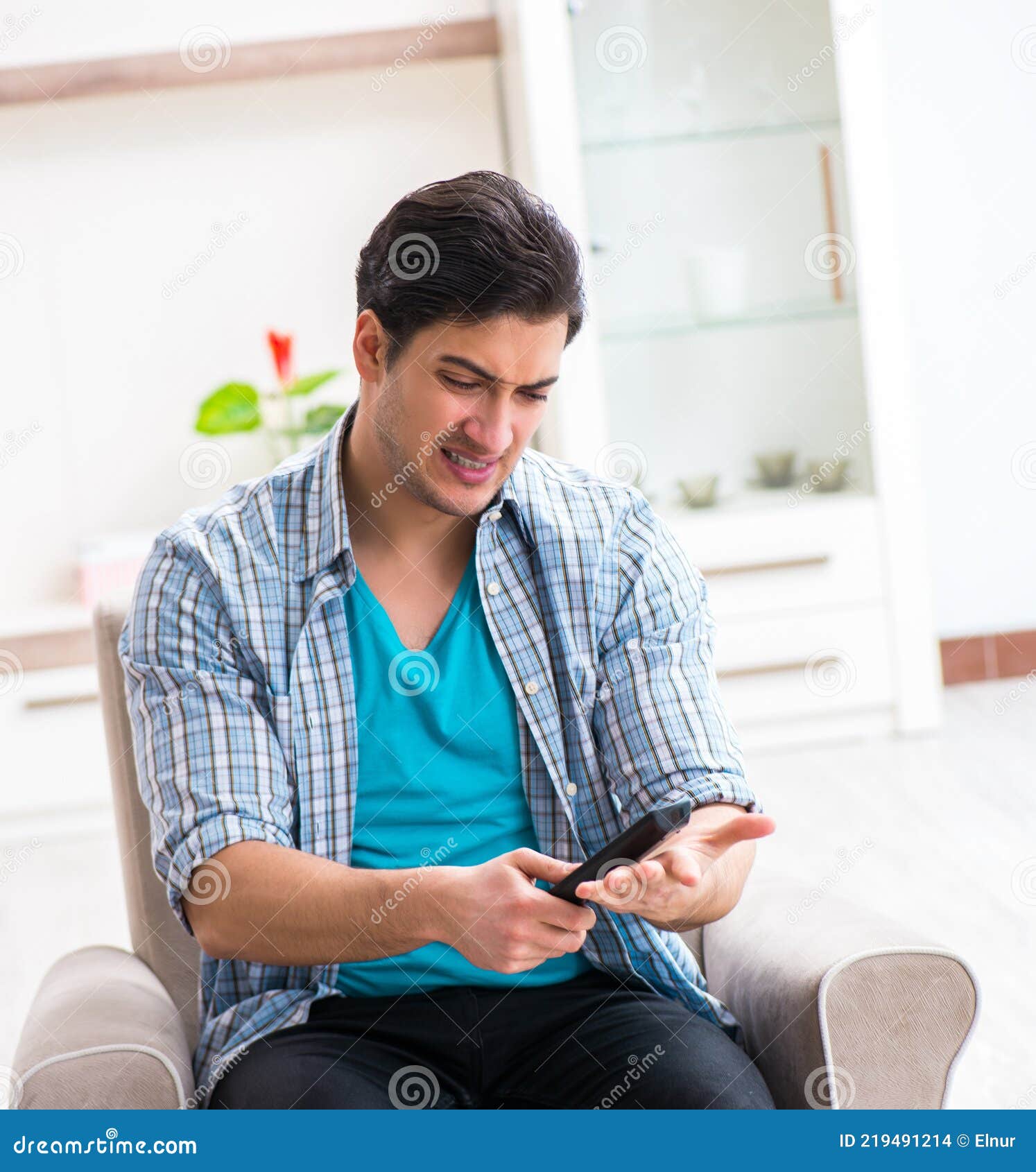 Man watching tv at home stock photo. Image of emotional - 219491214