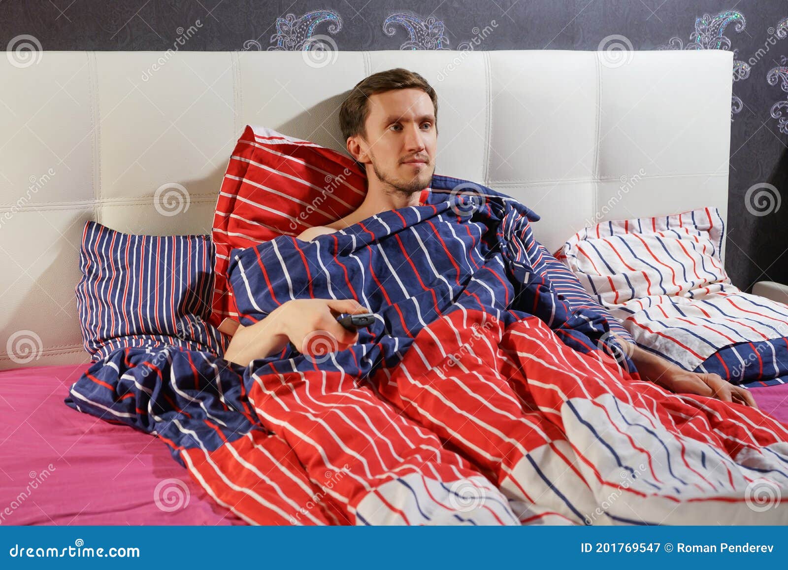 A Man is Watching Tv while Lying in Bed Stock Image - Image of lying ...