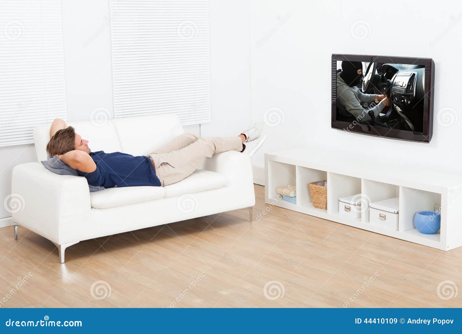 Man Watching Tv While Lying On Sofa Stock Photo - Image: 44410109