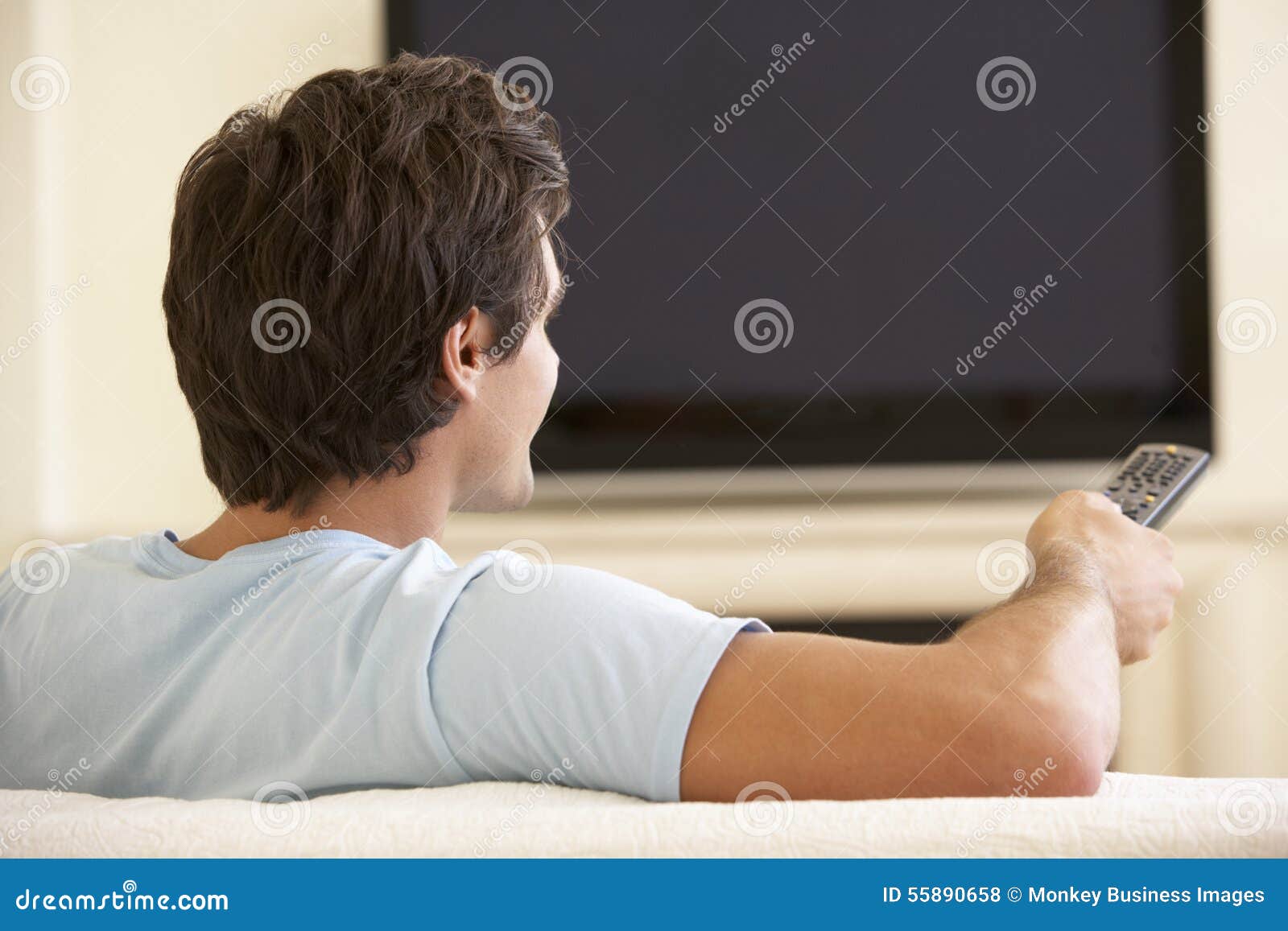 Man Watching Widescreen TV at Home Stock Photo - Image of remote, sofa ...