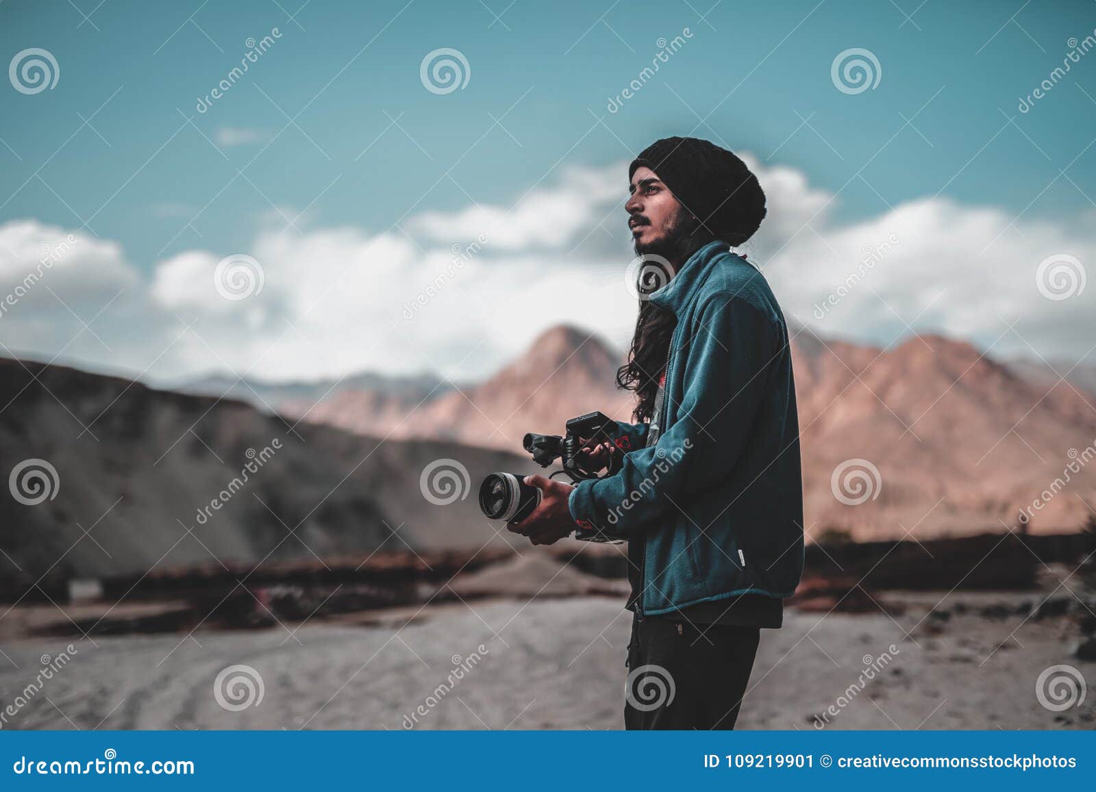 Man Wearing Jacket Holding Dslr Camera On Desert Picture. Image: 109219901
