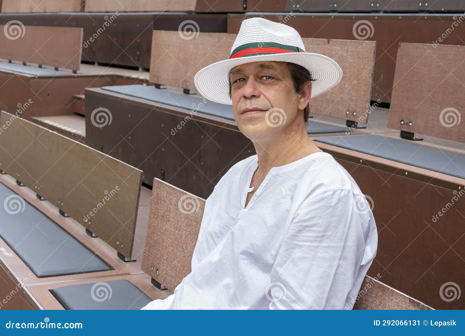 A Man Wearing White Robes and a Hat Sits in an Open Auditorium. Stock ...