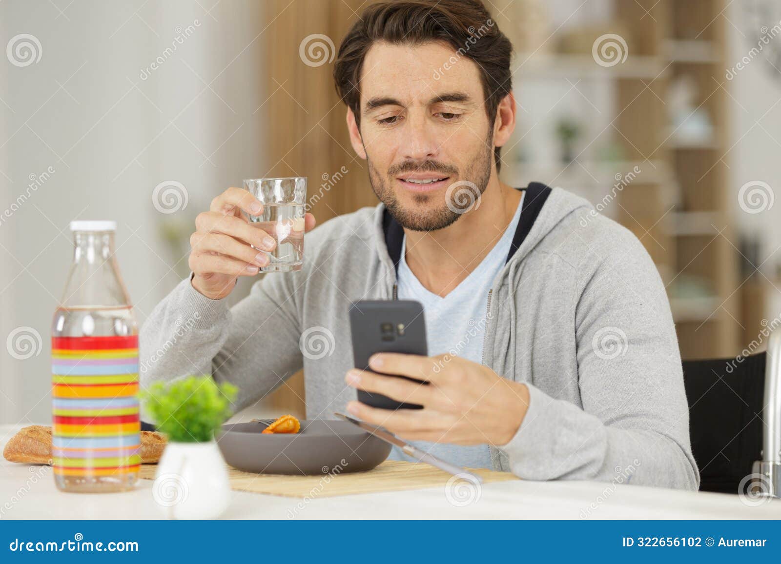 Man in Wheelchair Using Smartphone while Eating Meal Stock Photo ...