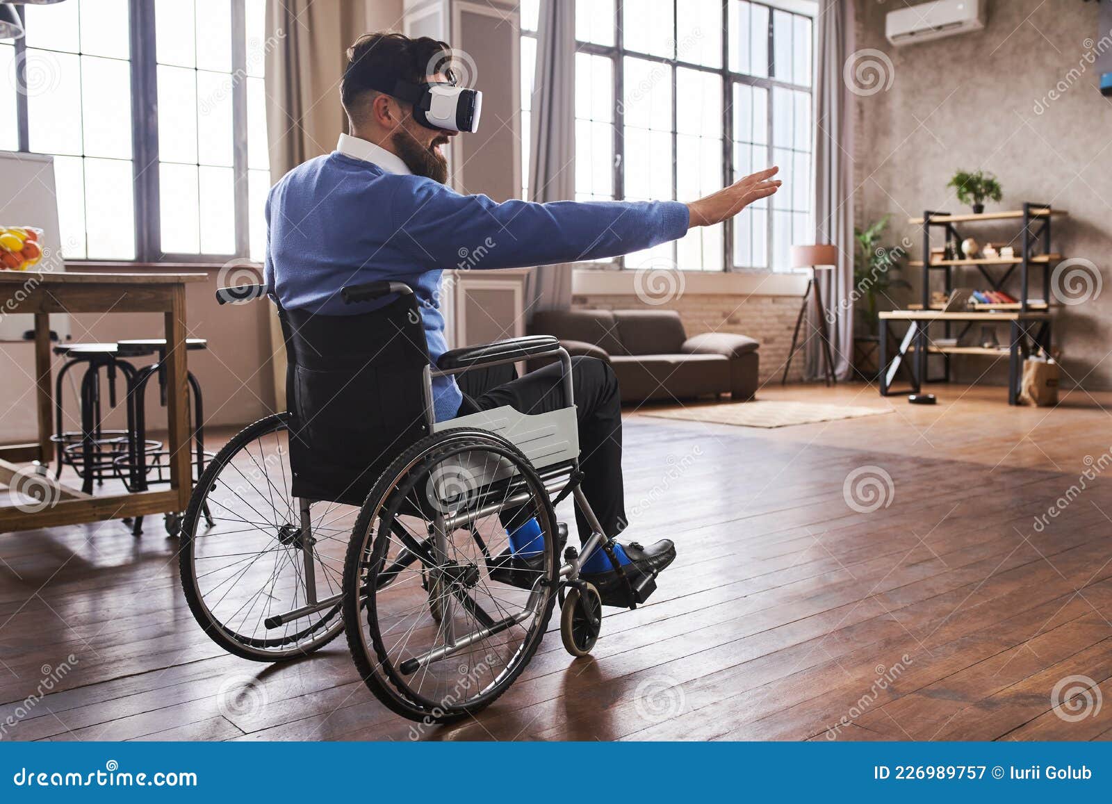 Man in a Wheelchair Using a VR Headset and Trying To Touch Virtual ...