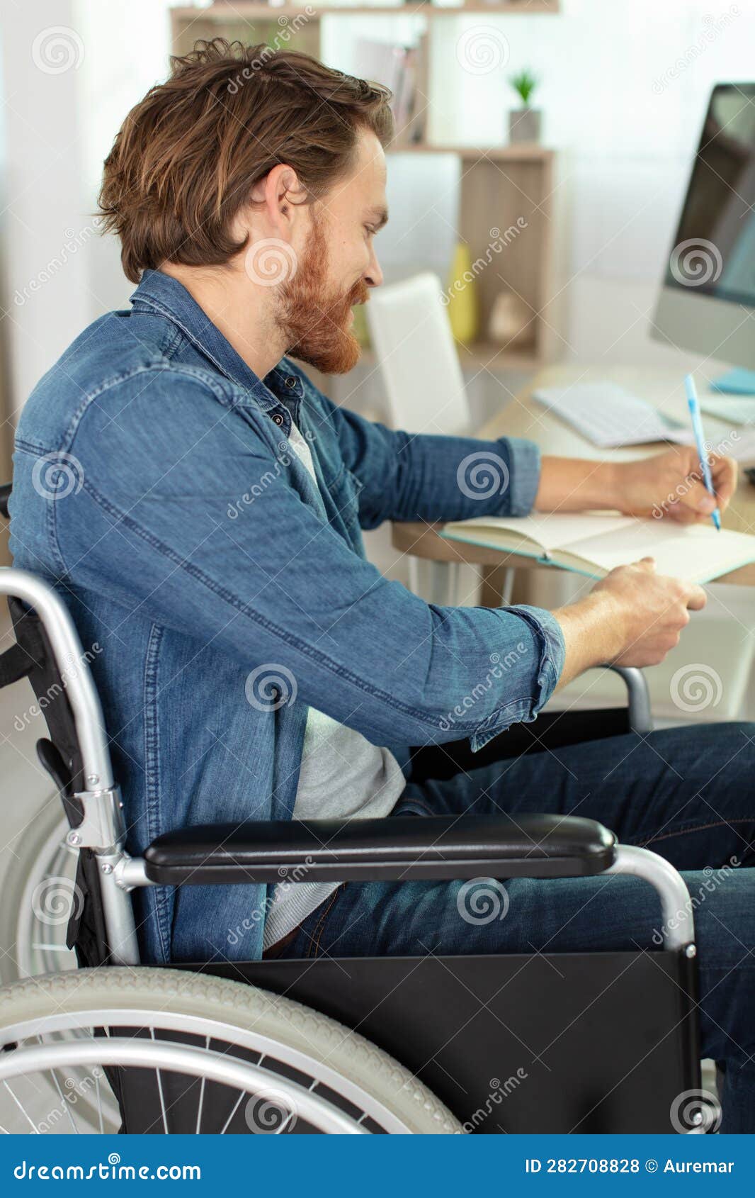 Man in Wheelchair Writing at Desk Stock Photo - Image of author ...