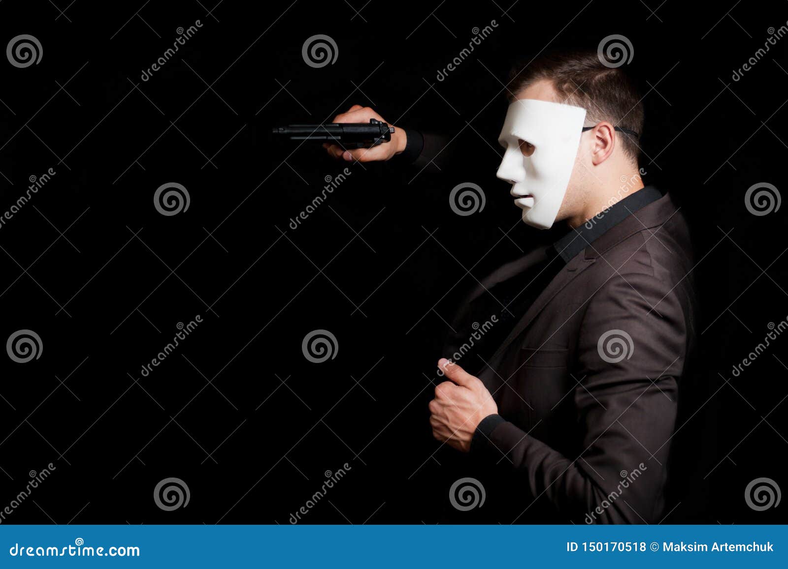A Man in a White Mask Shoots with a Pistol, on a Black Background Stock ...