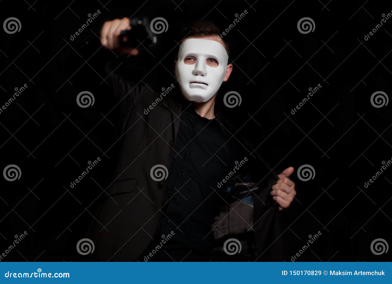 A Man in a White Mask Shoots with a Pistol, on a Black Background Stock ...