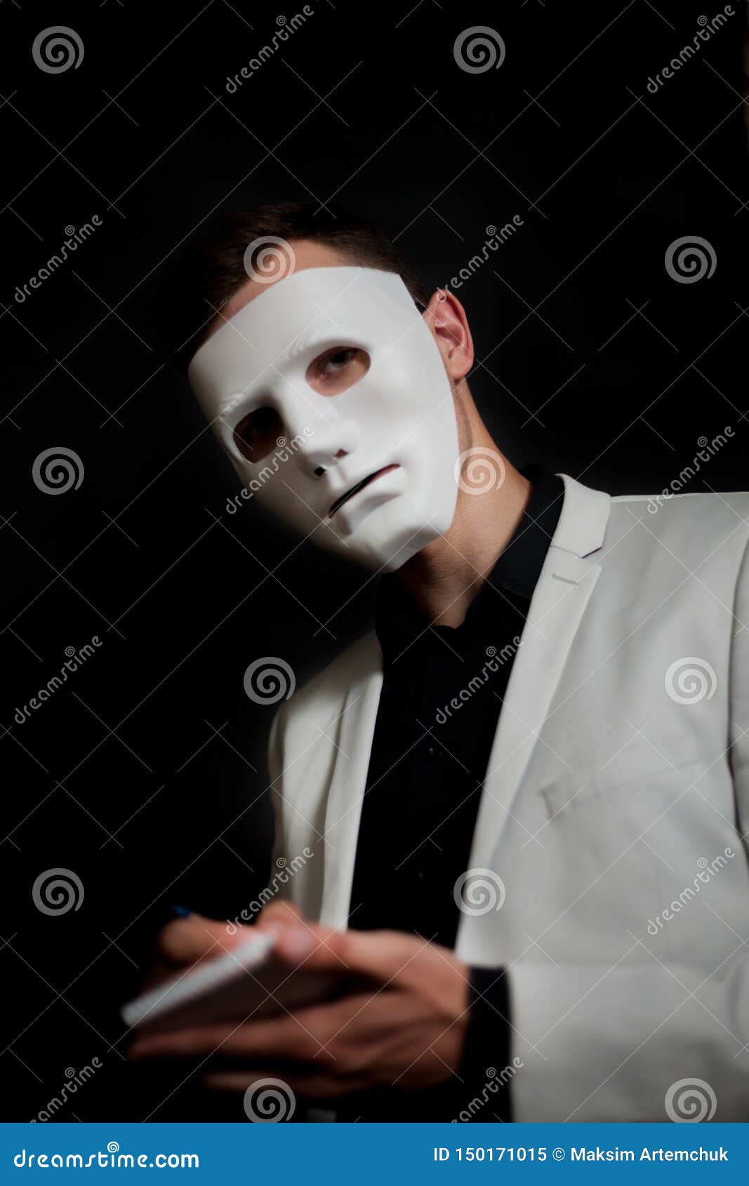 Man in a White Mask in a White Jacket on a Black Background Writes in a ...