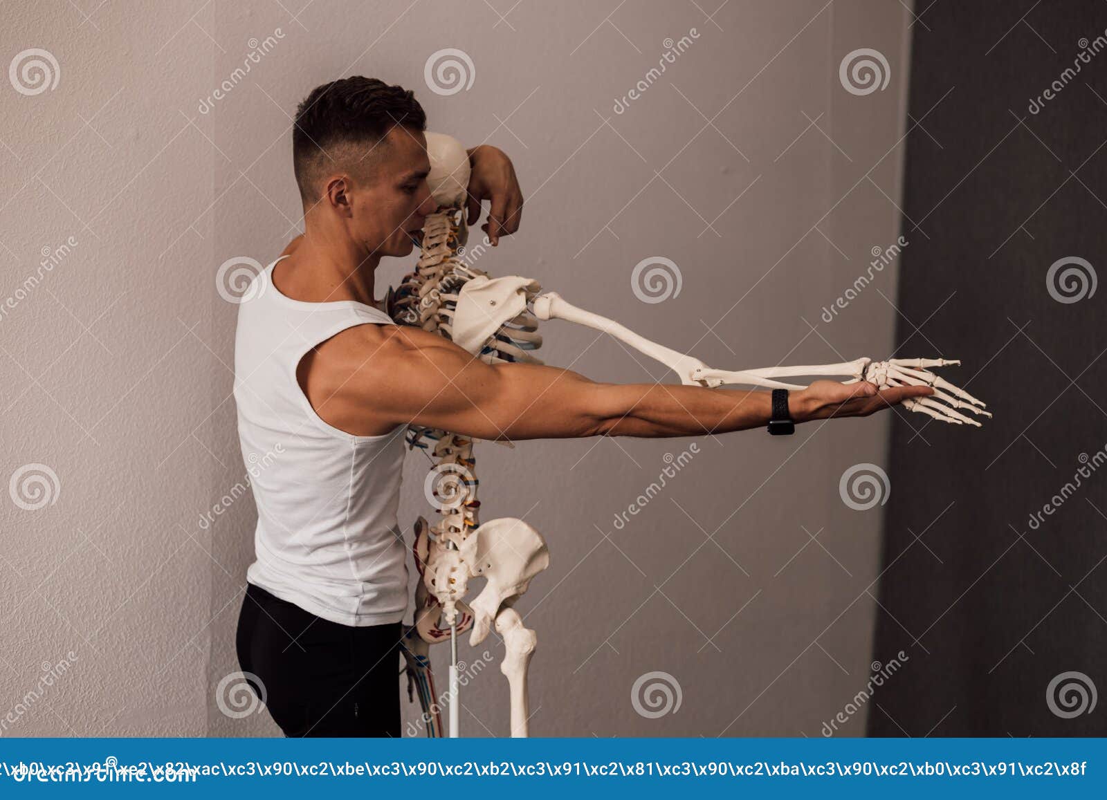 A Man in a White T-shirt Studies the Structure of the Human Skeleton ...