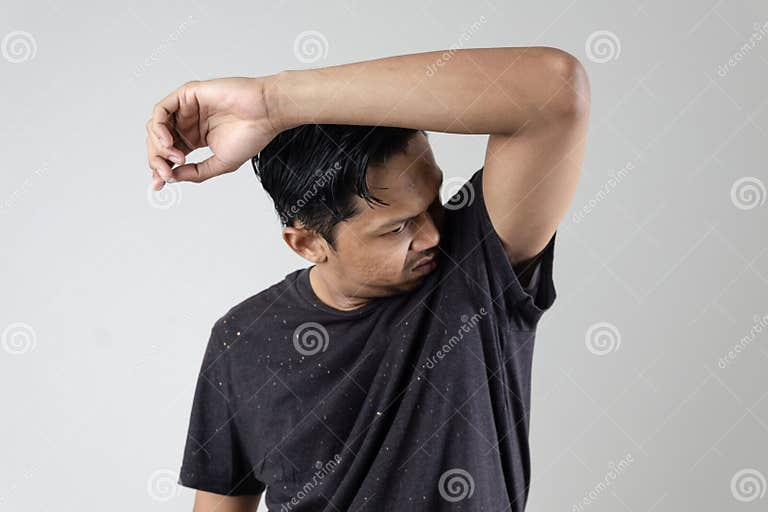 A Man Who Is Sweating After An Activity Smells His Own Armpits Feels Body Odor Sultry And 1604