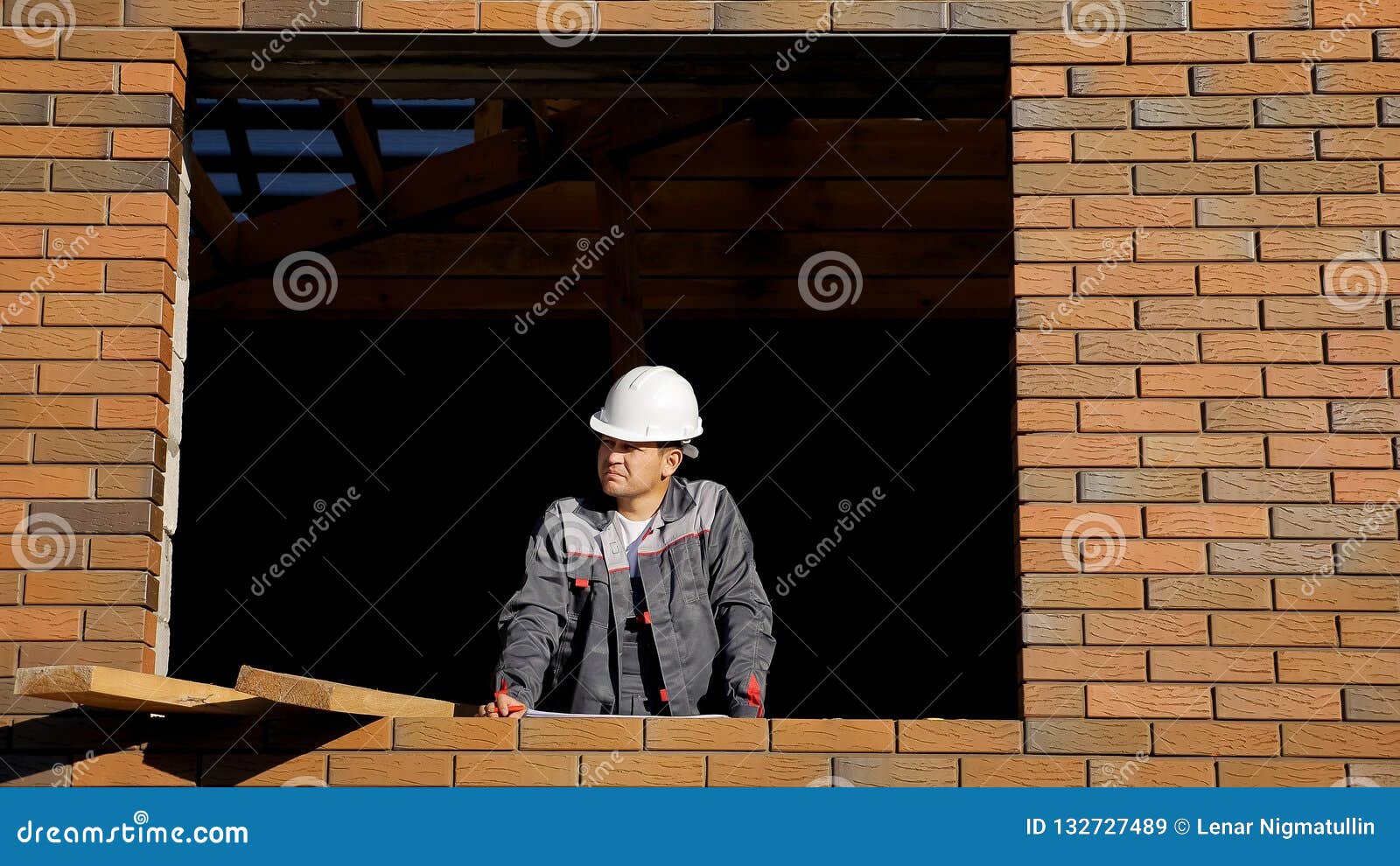 Man in Window of Building House Stock Image - Image of helmet, brick ...