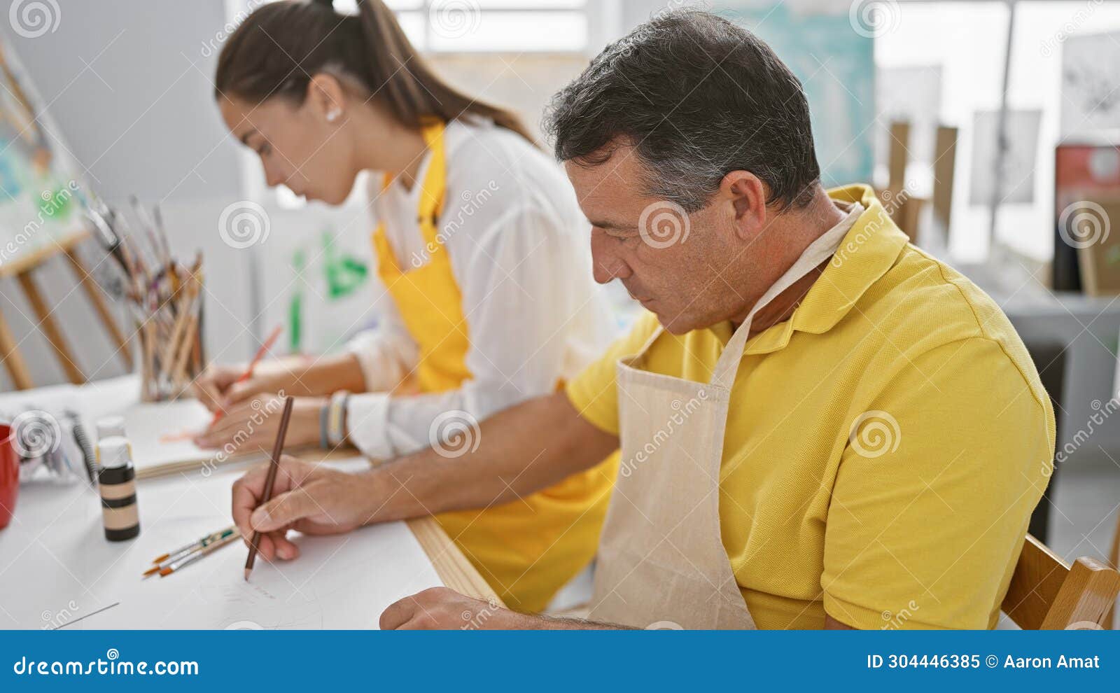 Man and Woman Artists, Deep in Concentration, Sitting Together in Art ...