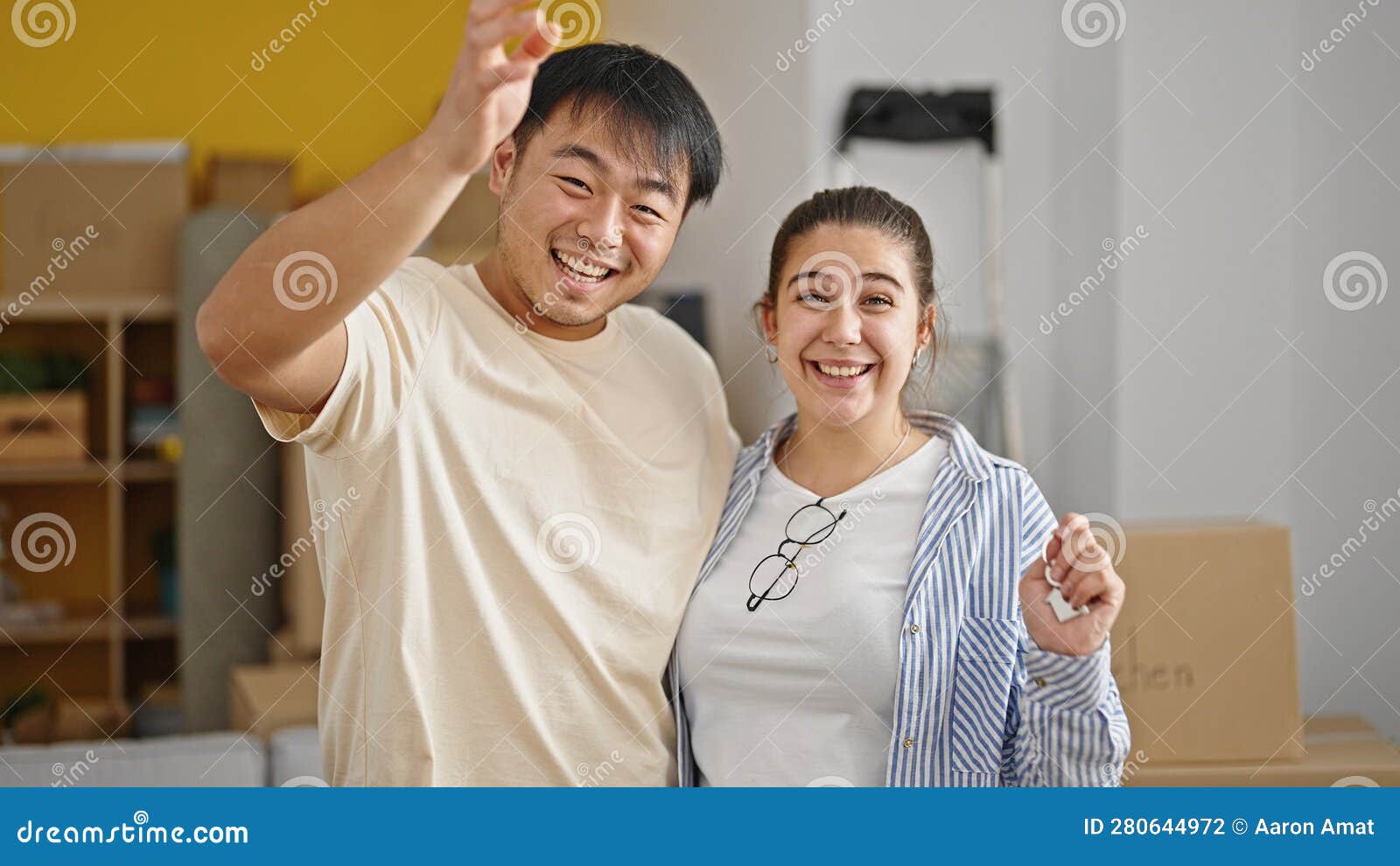 Man And Woman Couple Hugging Each Other Holding Keys At New Home Stock
