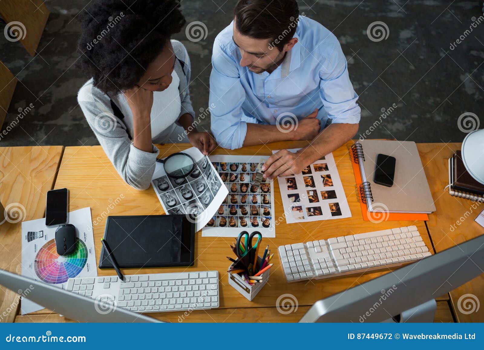 Man and Woman Discussing Over Photographs Stock Photo - Image of ...