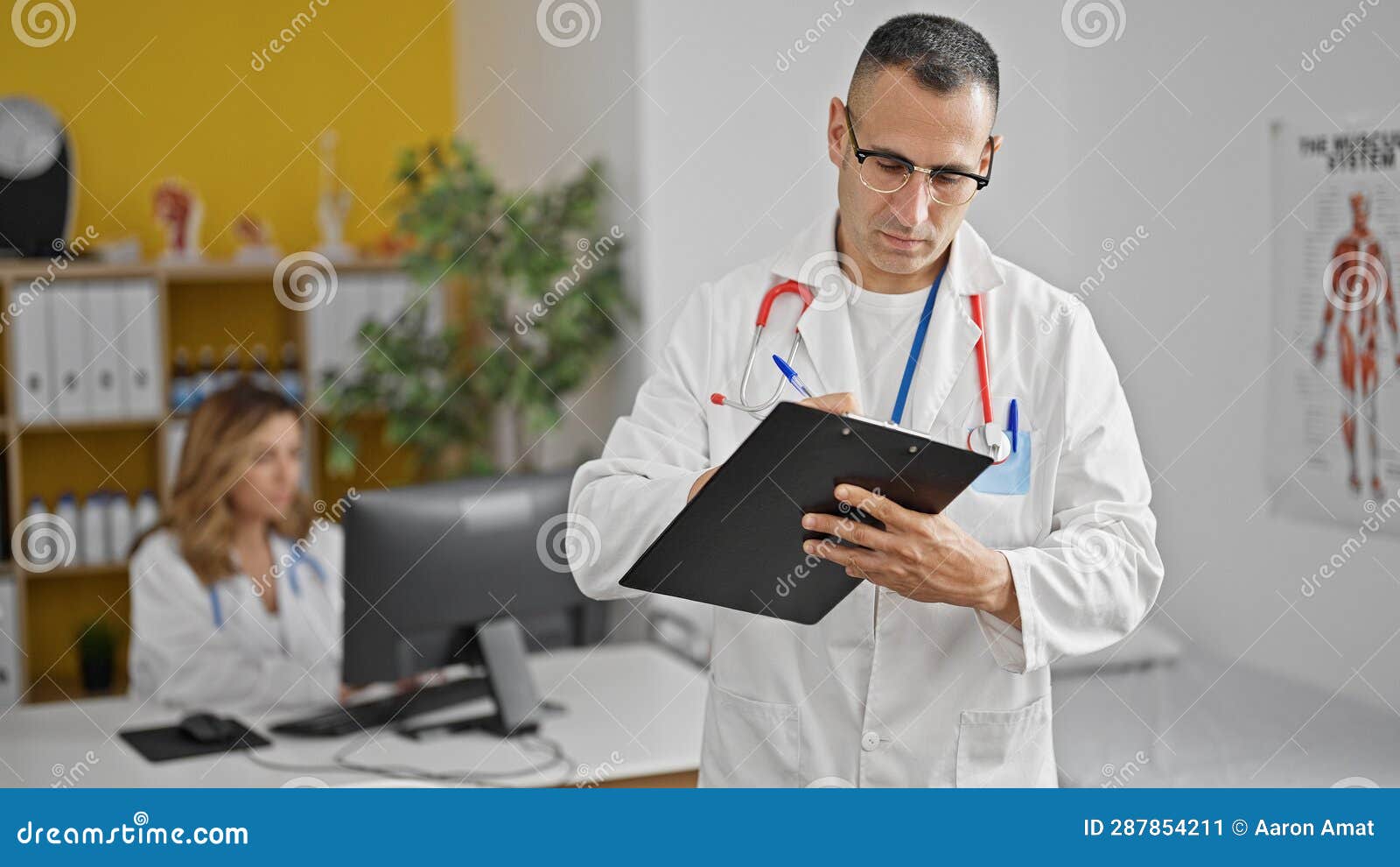 Man and Woman Doctors Writing Medical Report Using Computer Working at ...