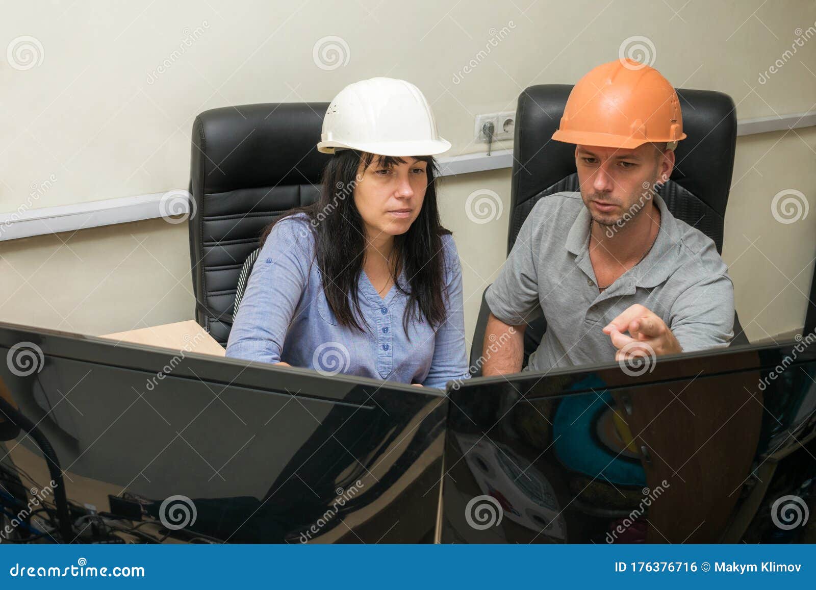 A Man and a Woman in Engineering Helmets Working in Front of the ...
