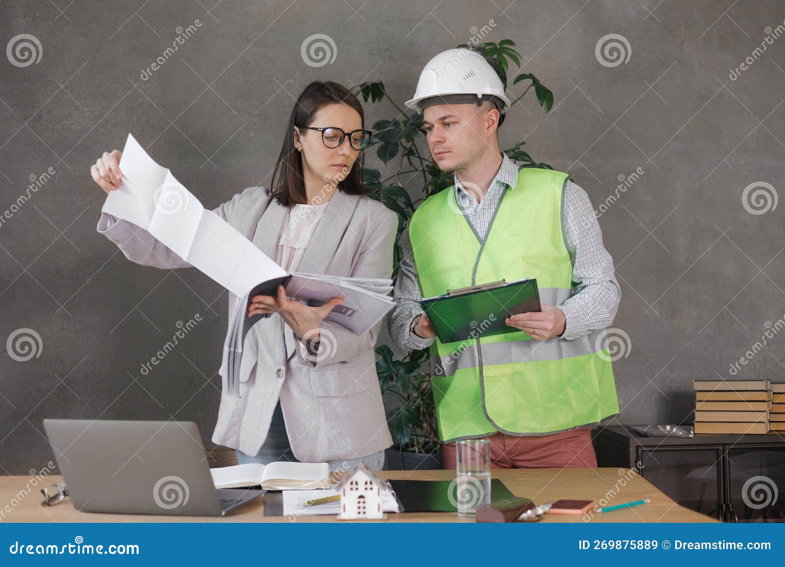 Man and Woman Engineers in Helmets in Office Check Drawing of ...