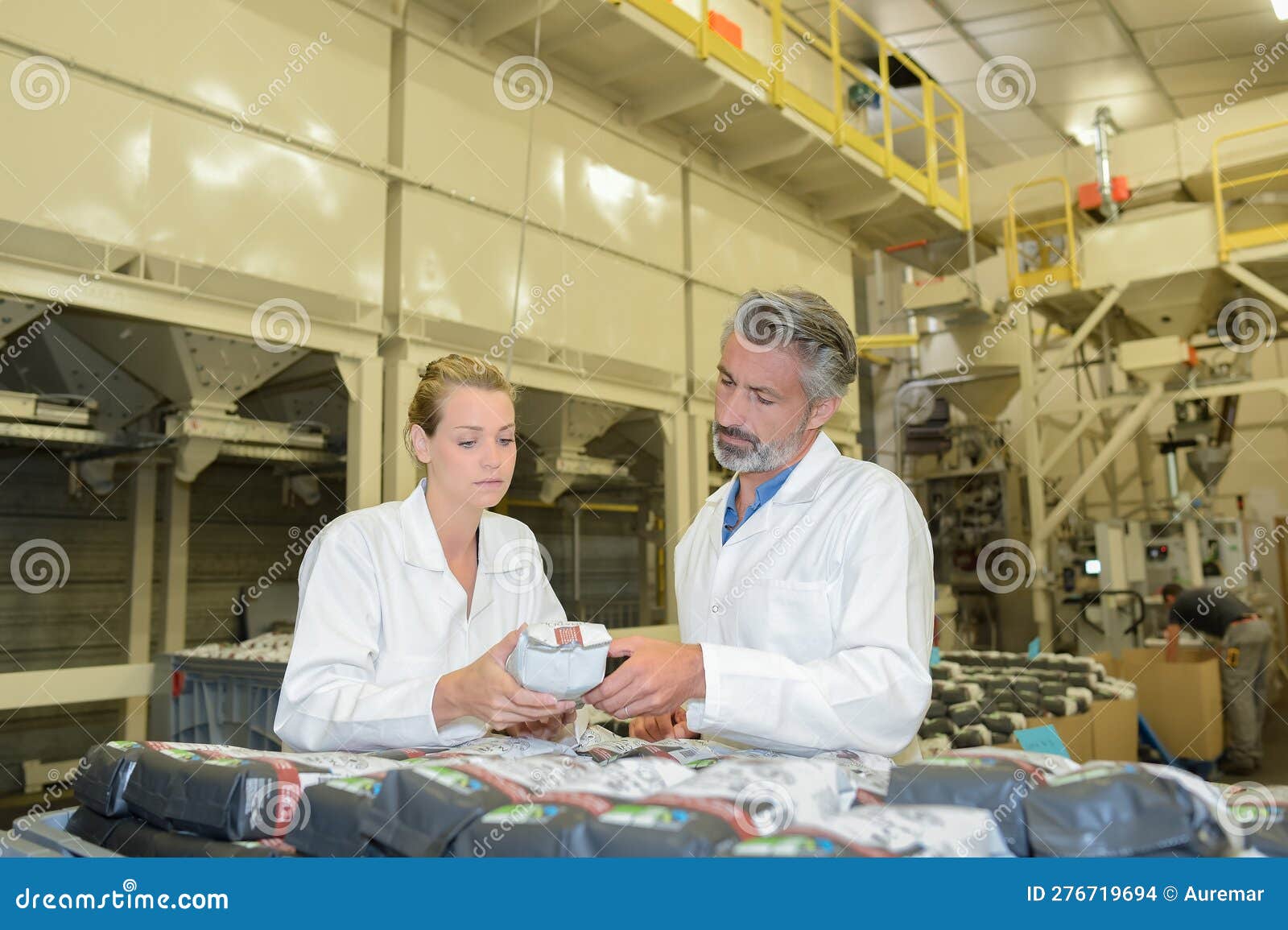 Man and Woman Inspecting Packets in Factory Stock Photo - Image of ...