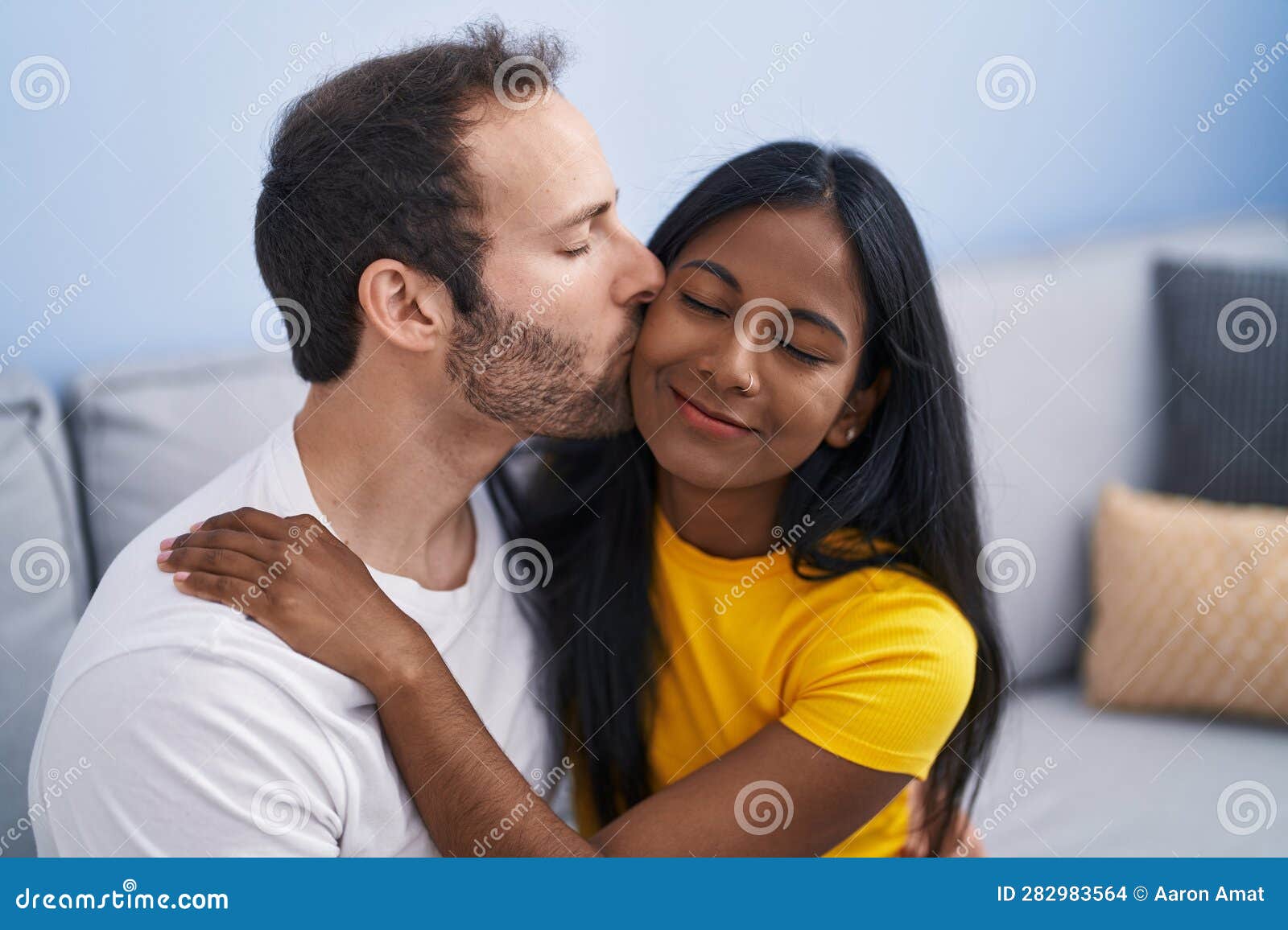 Man And Woman Interracial Couple Hugging Each Other And Kissing At Home