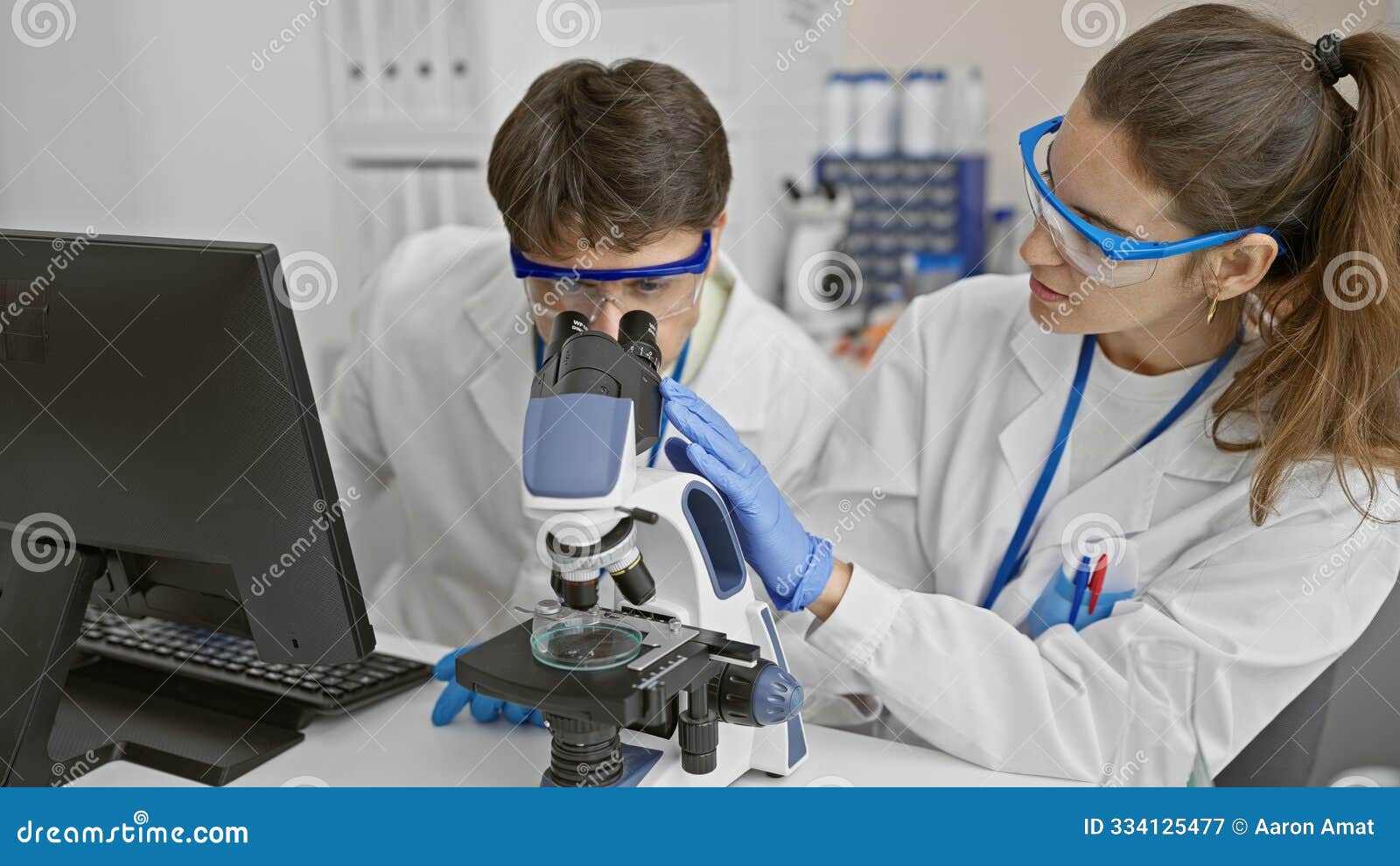 A Man and a Woman in Lab Coats Using a Microscope in a Laboratory ...