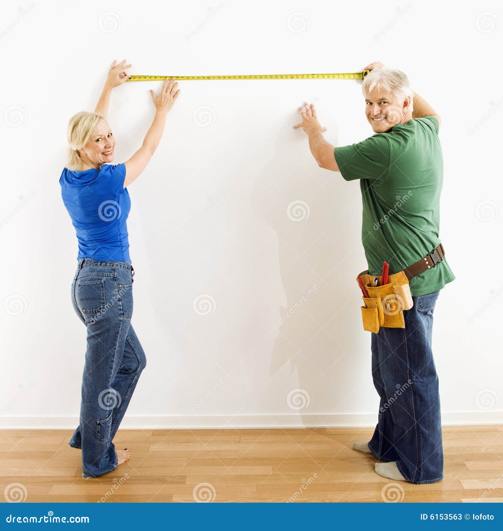 Man and Woman Measuring Wall. Stock Image - Image of indoors, looking ...
