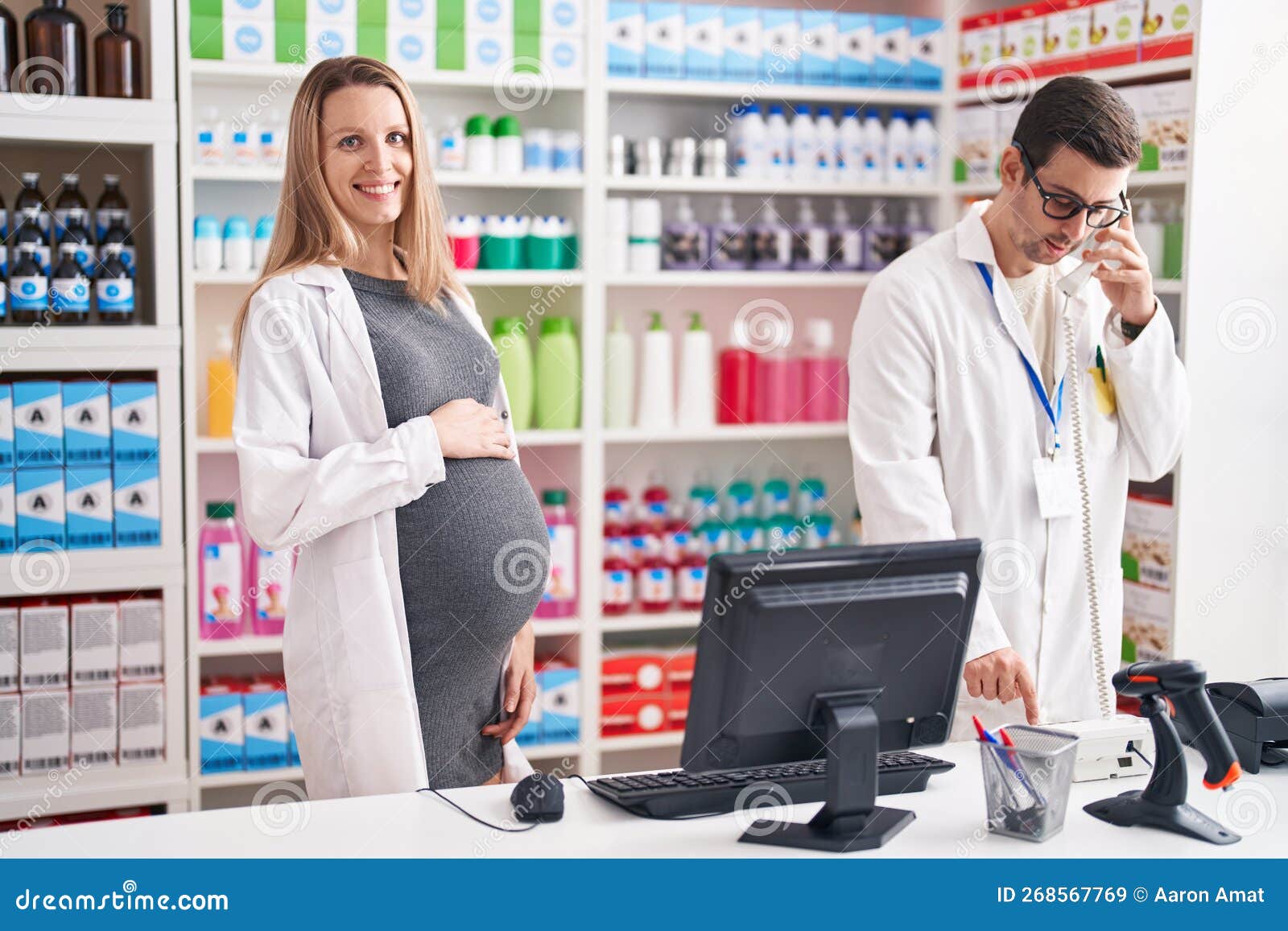 Man and Woman Pharmacists Using Computer Talking on Telephone at ...