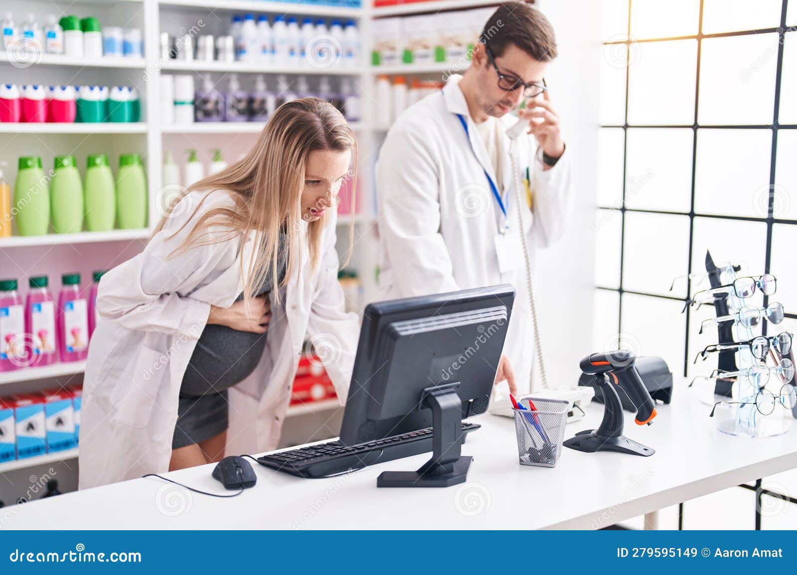 Man and Woman Pharmacists Using Computer Talking on Telephone at ...