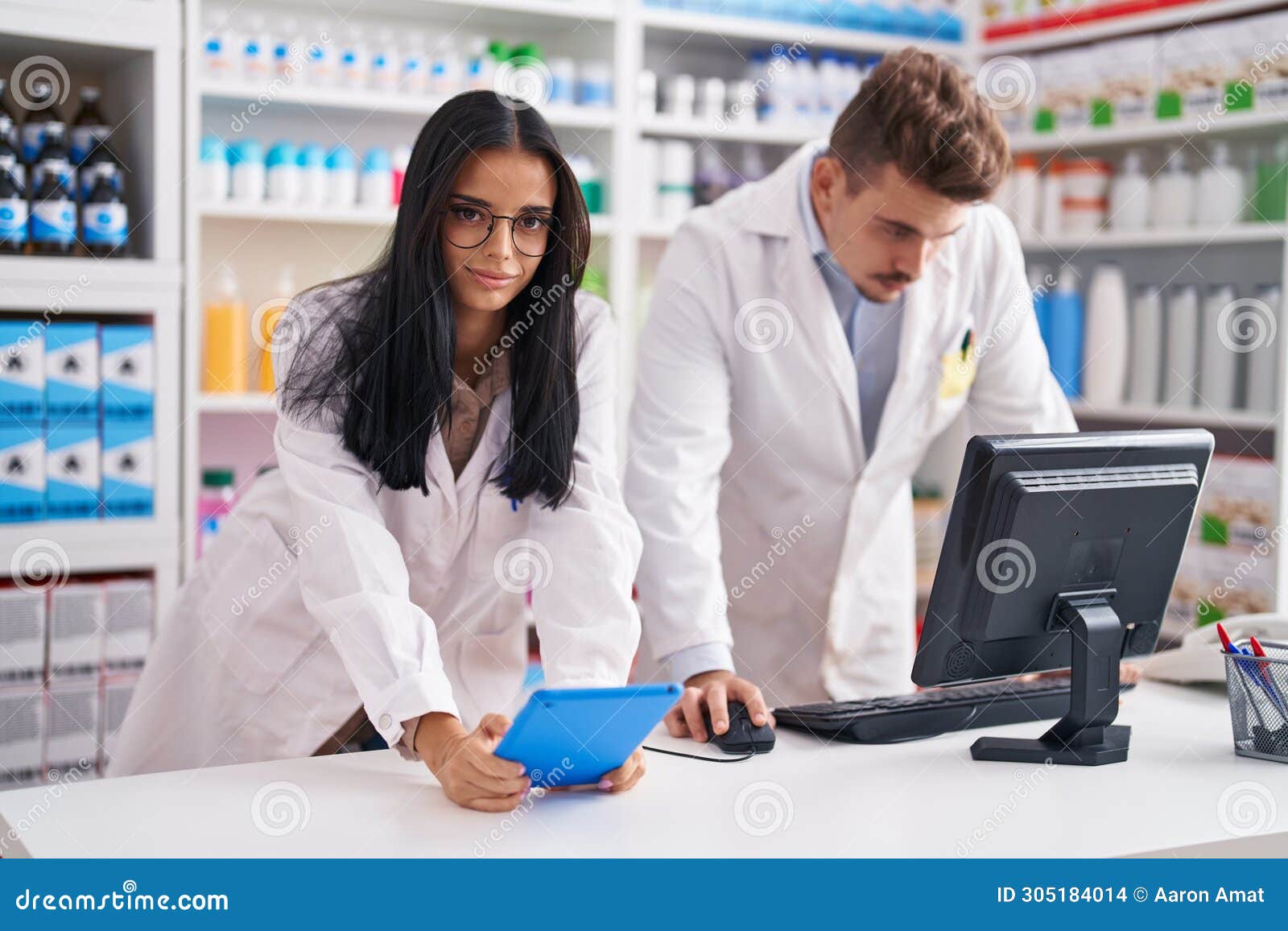 Man and Woman Pharmacists Using Touchpad and Computer Working at ...