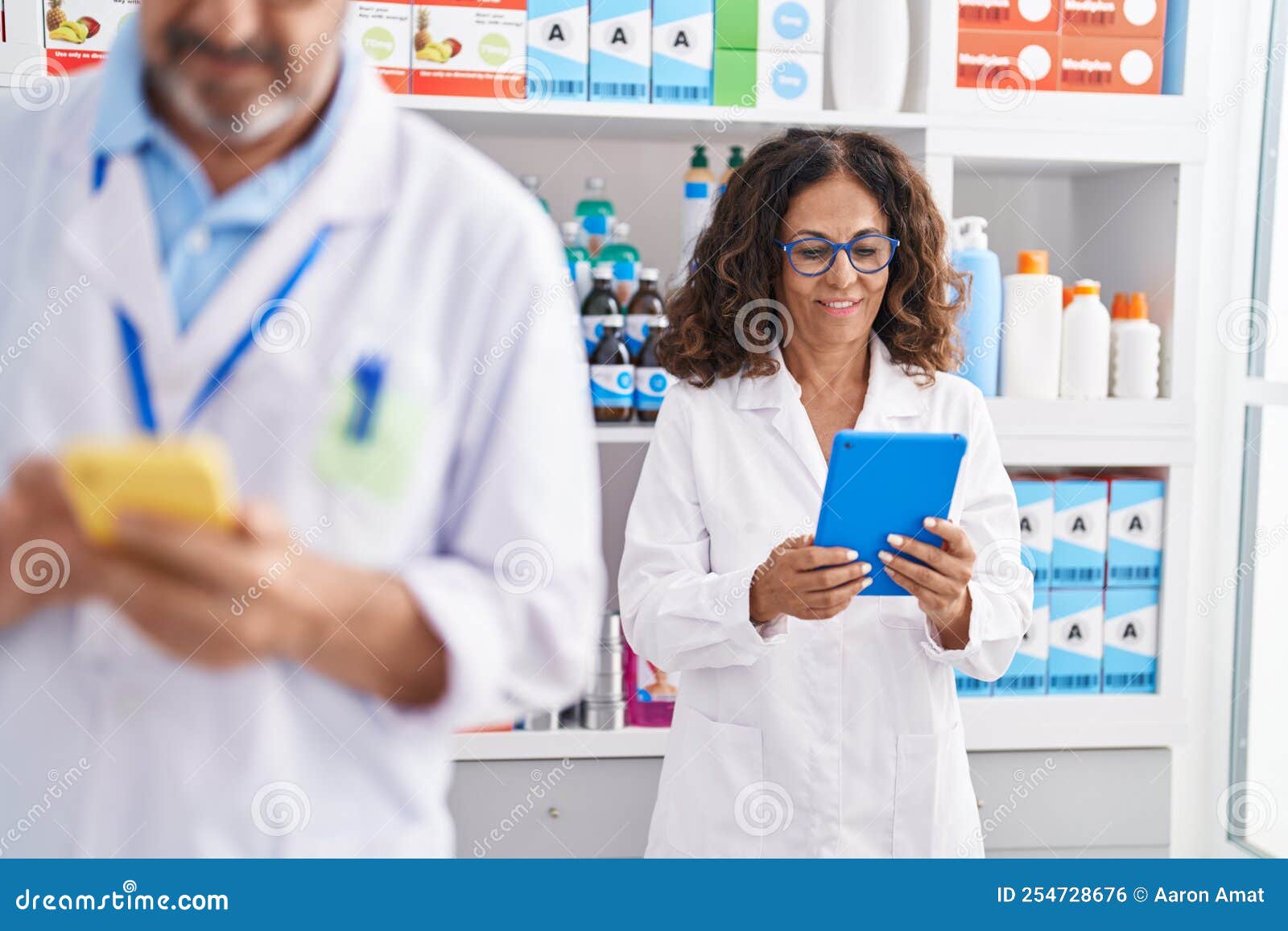 Man and Woman Pharmacists Using Touchpad and Smartphone Working at ...