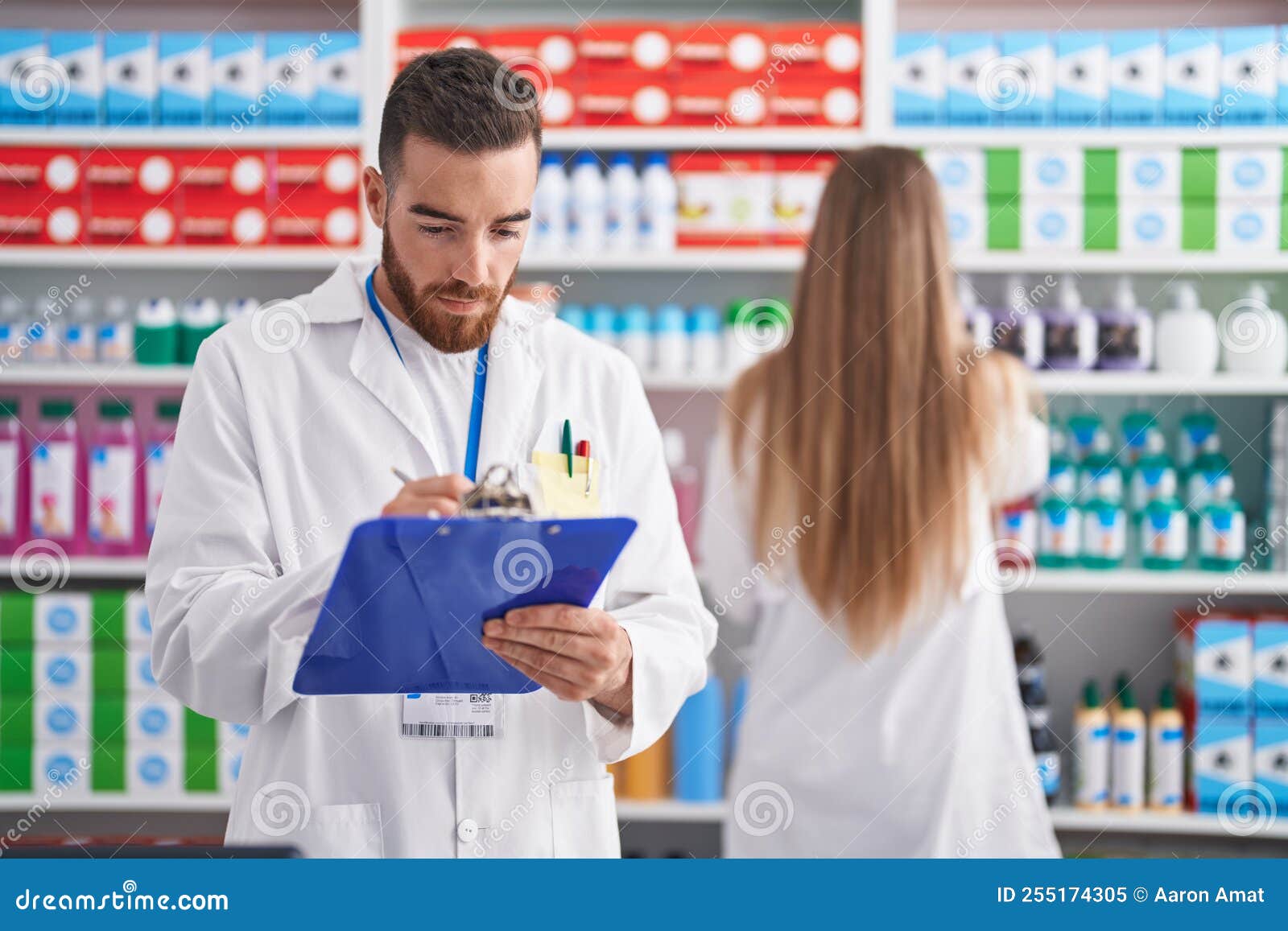 Man and Woman Pharmacists Writing on Document at Pharmacy Stock Image ...