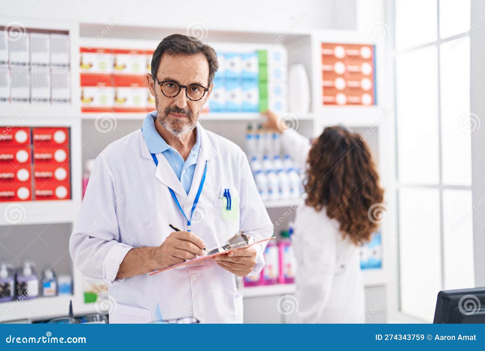 Man and Woman Pharmacists Writing on Document Working at Pharmacy Stock ...