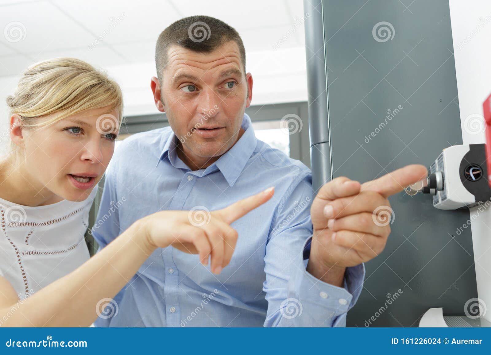 Man and Woman Push Finger Down on Fingerprint Machine Stock Photo ...