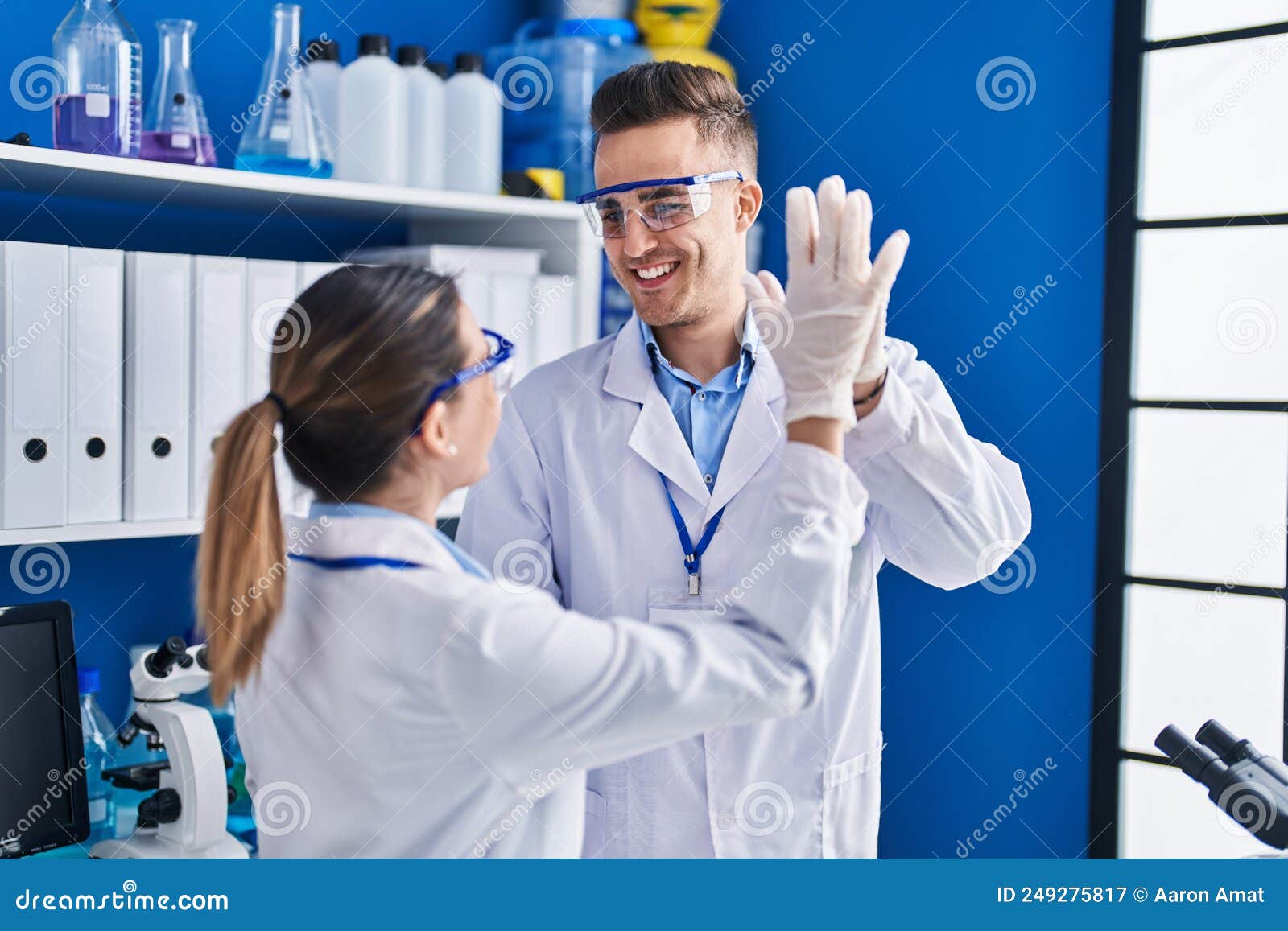 Man and Woman Scientists High Five with Hands Raised Up at Laboratory ...