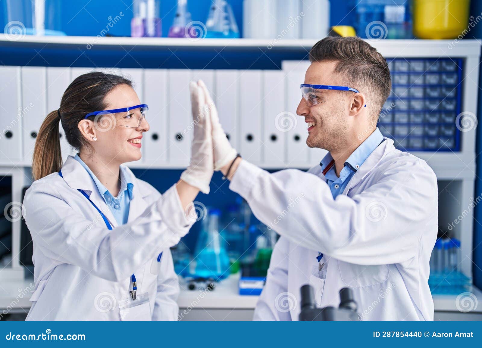 Man and Woman Scientists High Five with Hands Raised Up at Laboratory ...
