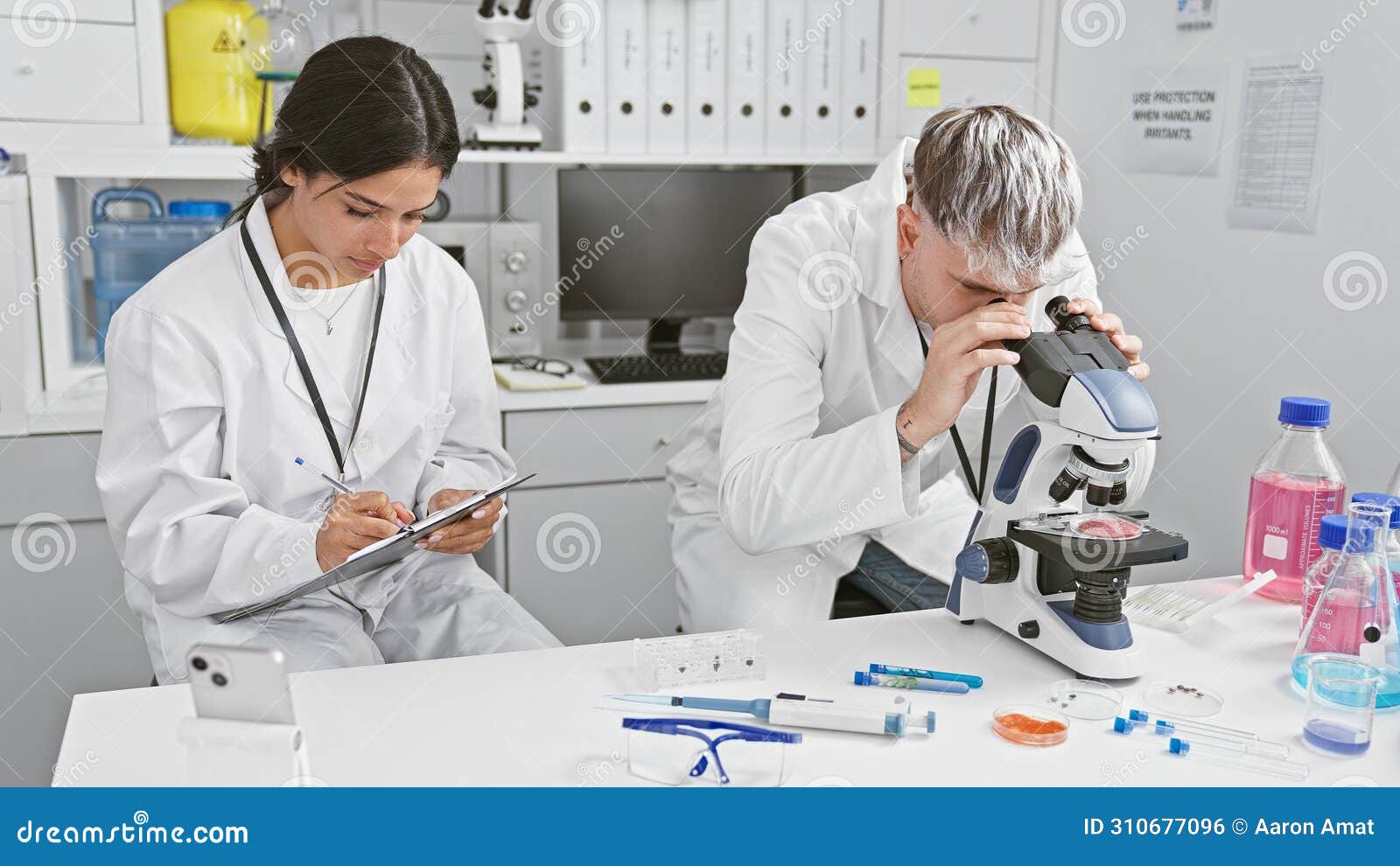 Man and Woman Scientists in Laboratory, Working with Microscope and ...