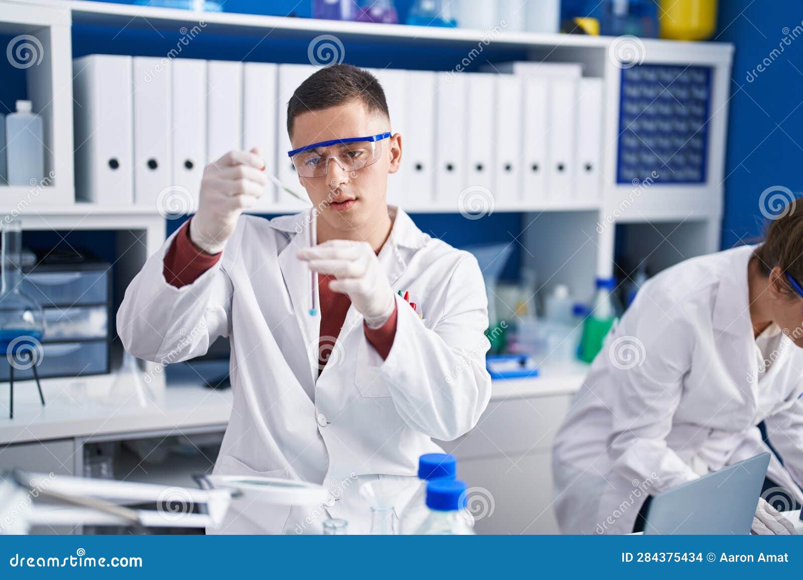 Man and Woman Scientists Measuring Liquid at Laboratory Stock Photo ...