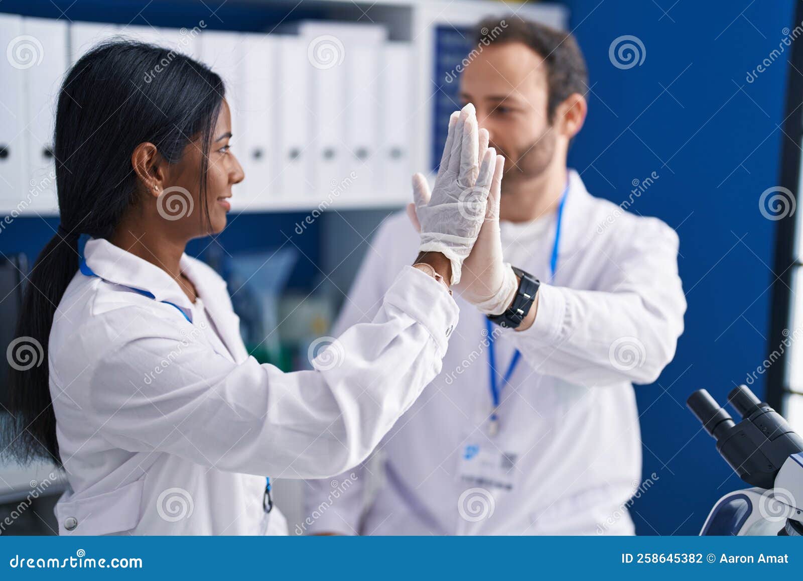 Man and Woman Scientists Smiling Confident High Five at Laboratory ...