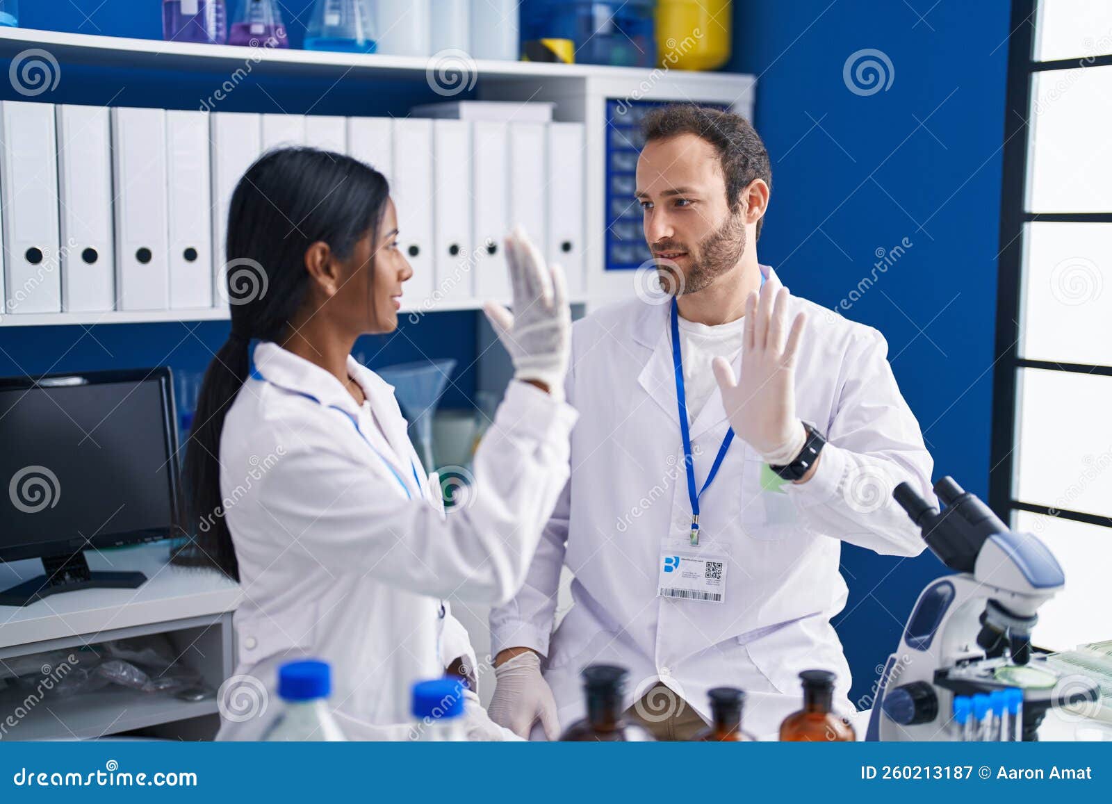 Man and Woman Scientists Smiling Confident High Five at Laboratory ...
