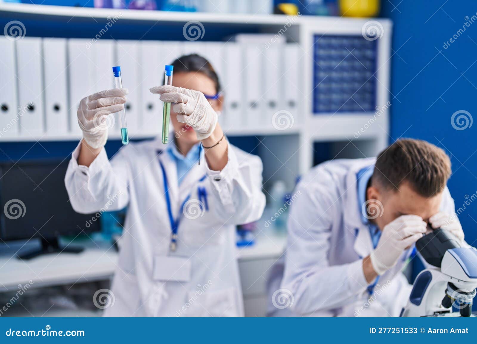 Man and Woman Scientists Using Microscope Holding Test Tubes at ...