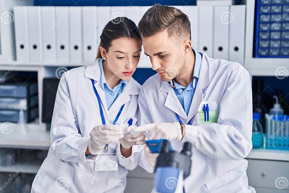 Man and Woman Scientists Using Smartphone Looking Sample at Laboratory ...