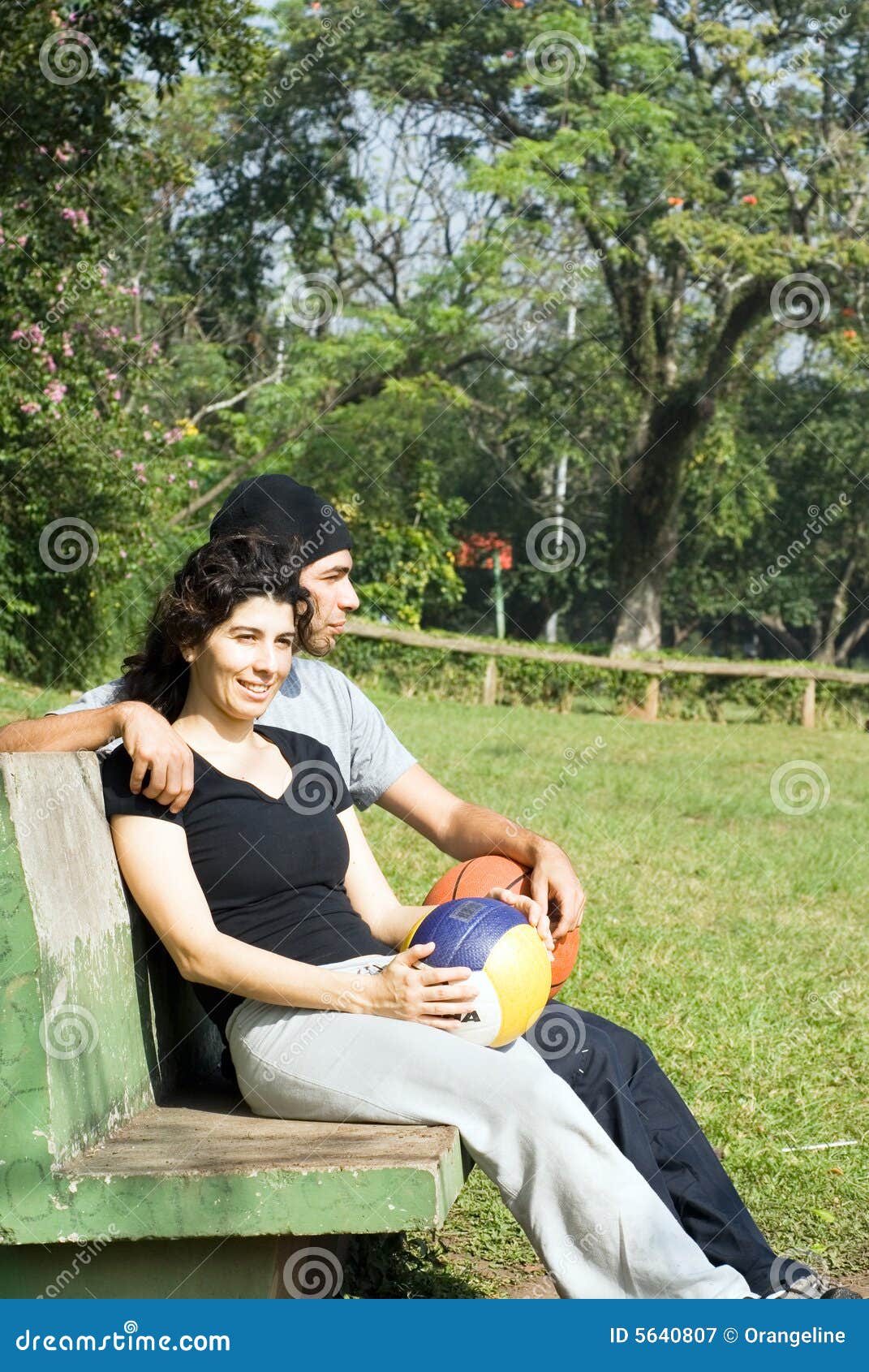 Man and Woman Sitting on a Park Bench - Vertical Stock Image - Image of ...