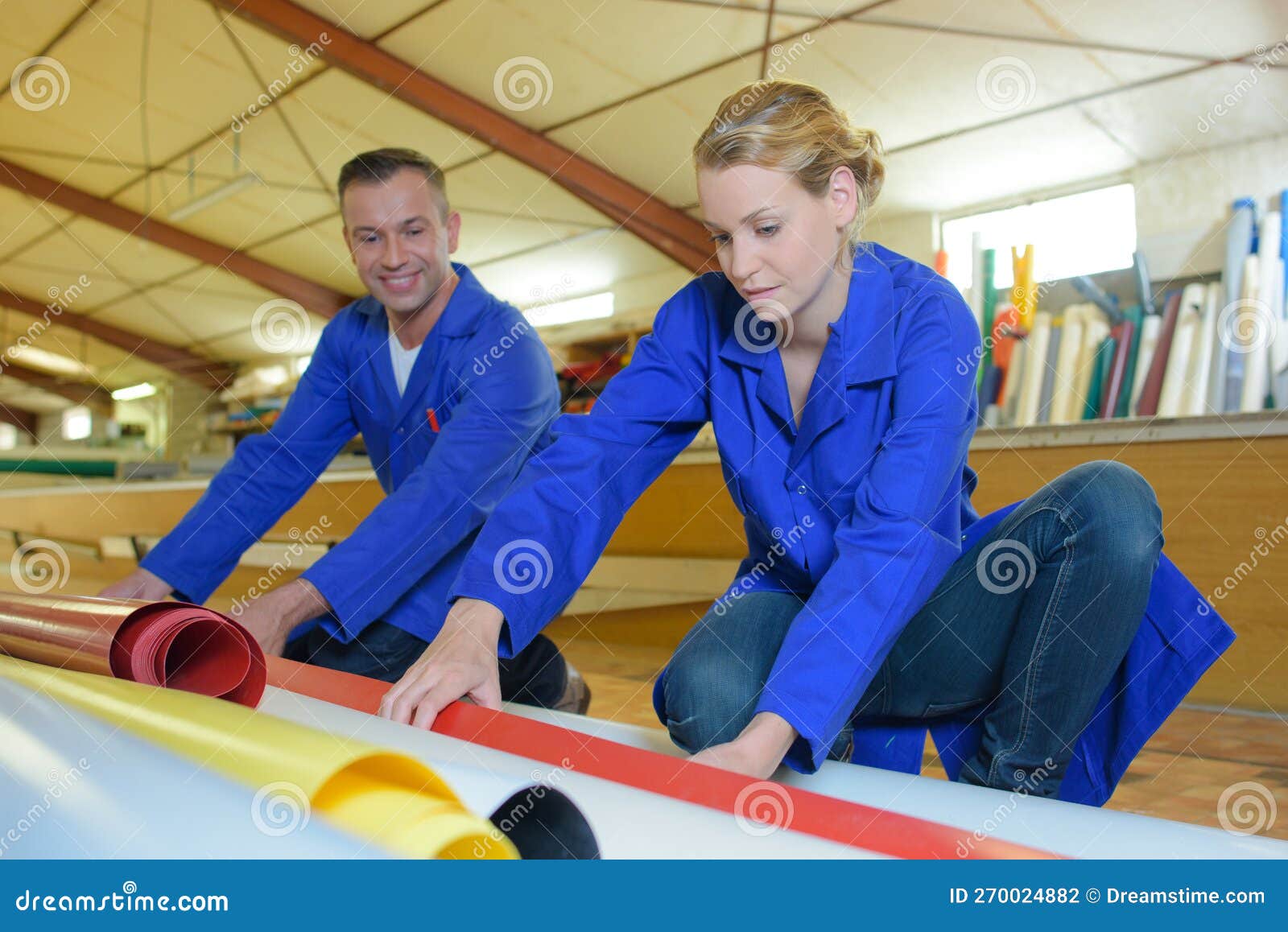 Man and Woman Unrolling Material Stock Photo - Image of warehouse ...