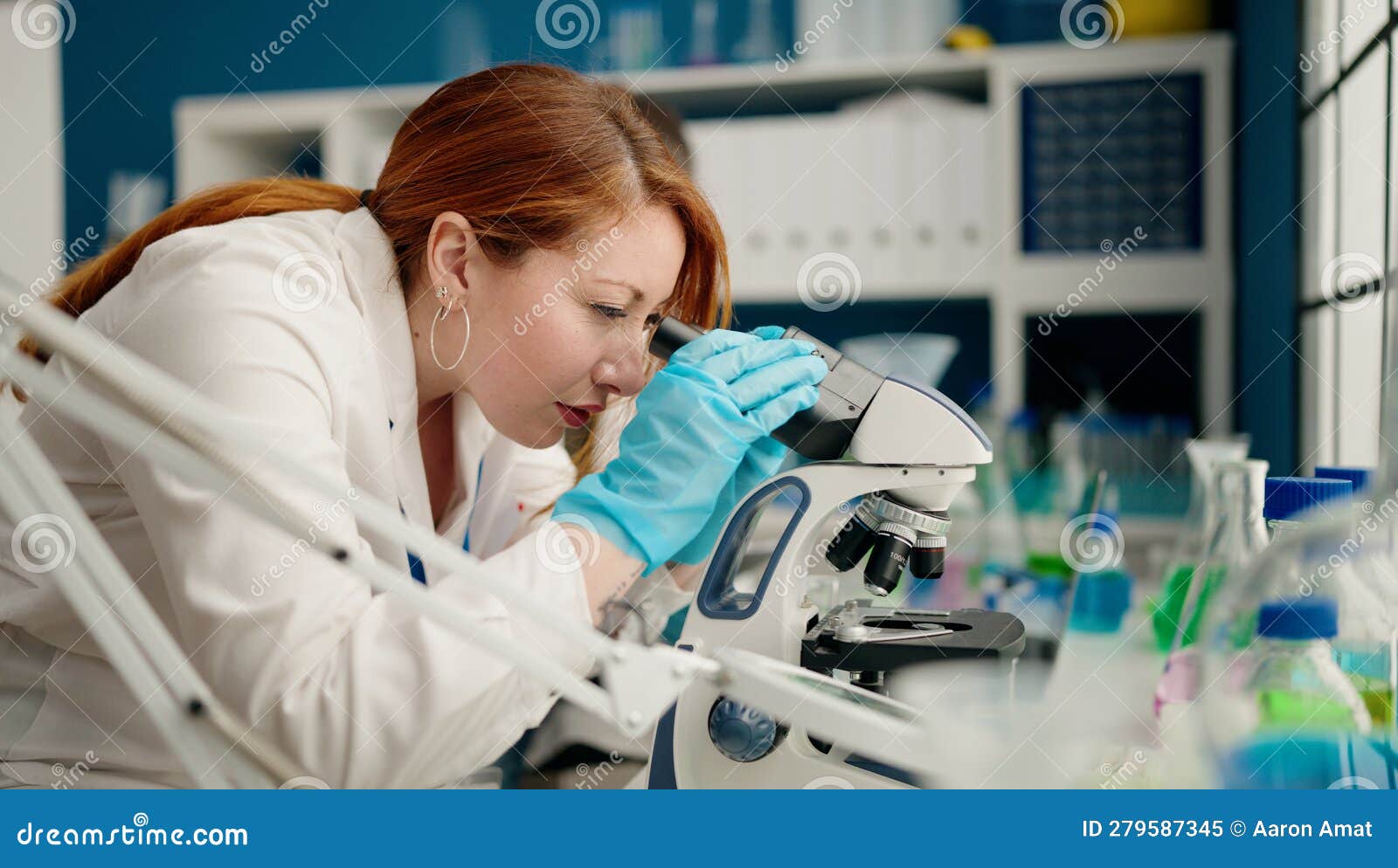 Man and Woman Wearing Sciencist Uniform Using Microscope at Laboratory ...