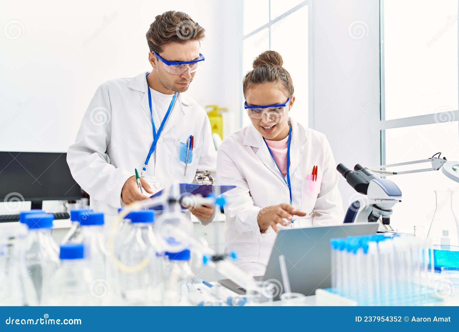 Man and Woman Wearing Scientist Uniform Using Laptop Working at ...