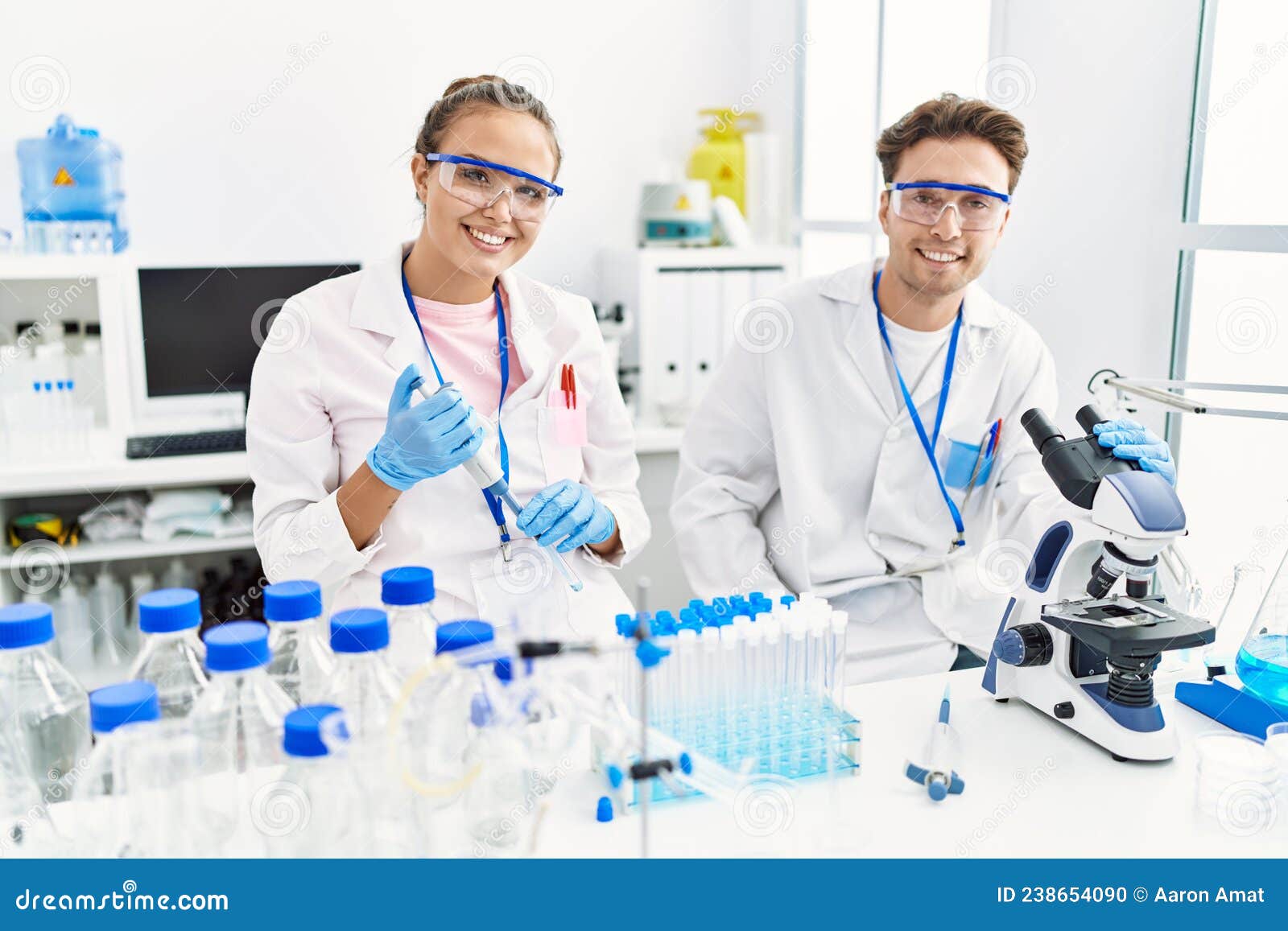 Man and Woman Wearing Scientist Uniform Using Pipette and Microscope ...