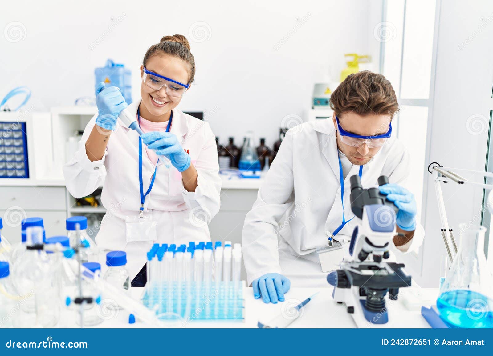Man and Woman Wearing Scientist Uniform Using Pipette and Microscope ...