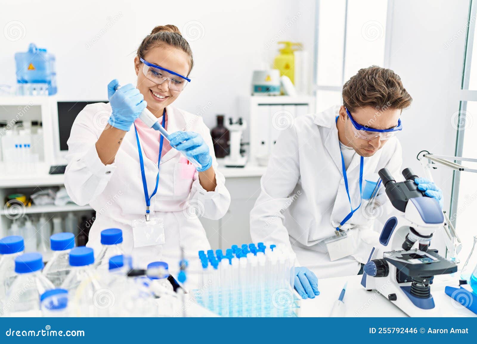 Man and Woman Wearing Scientist Uniform Using Pipette and Microscope ...